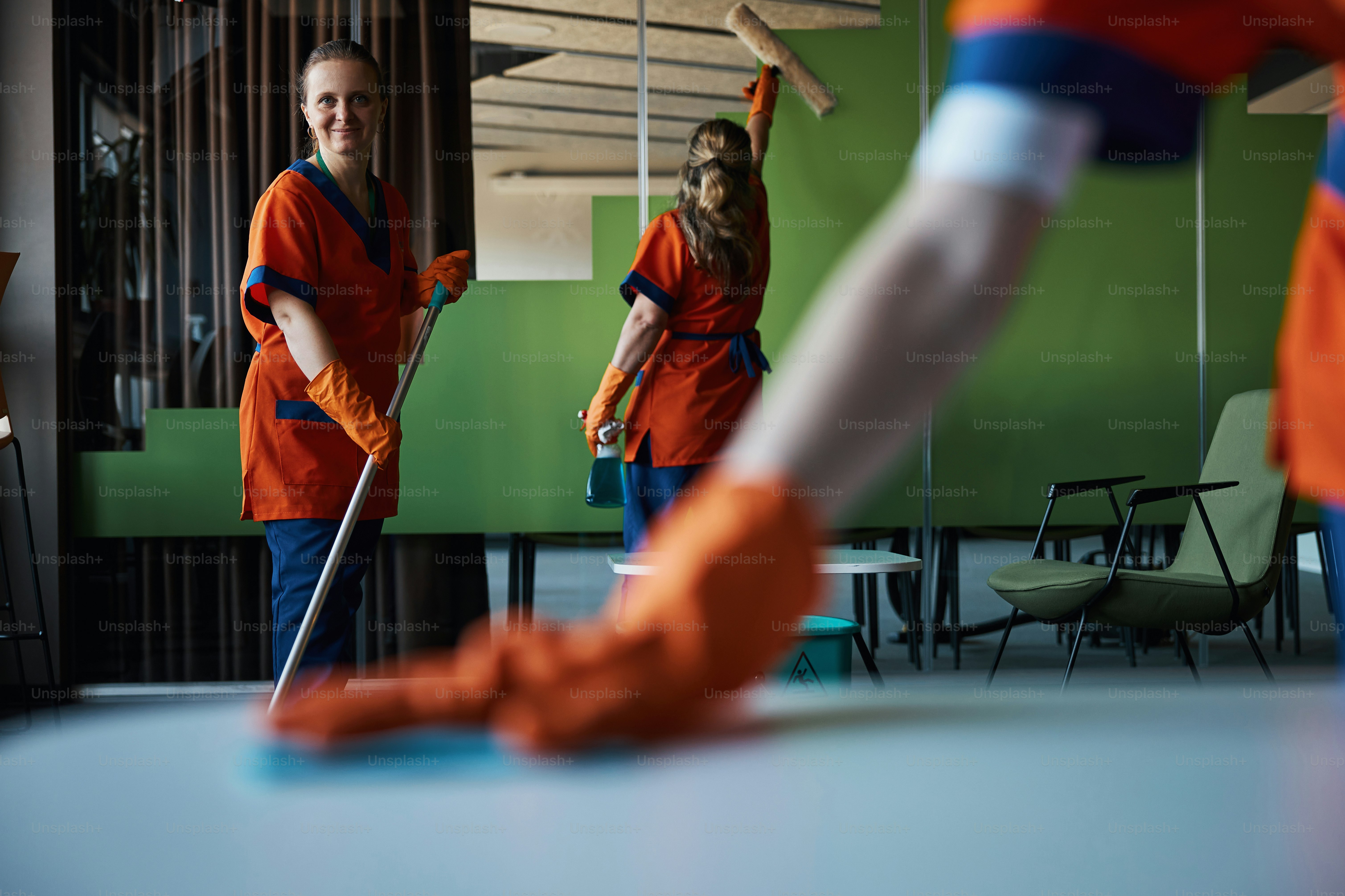 Smiling young female worker in the uniform leaning over a corded ...