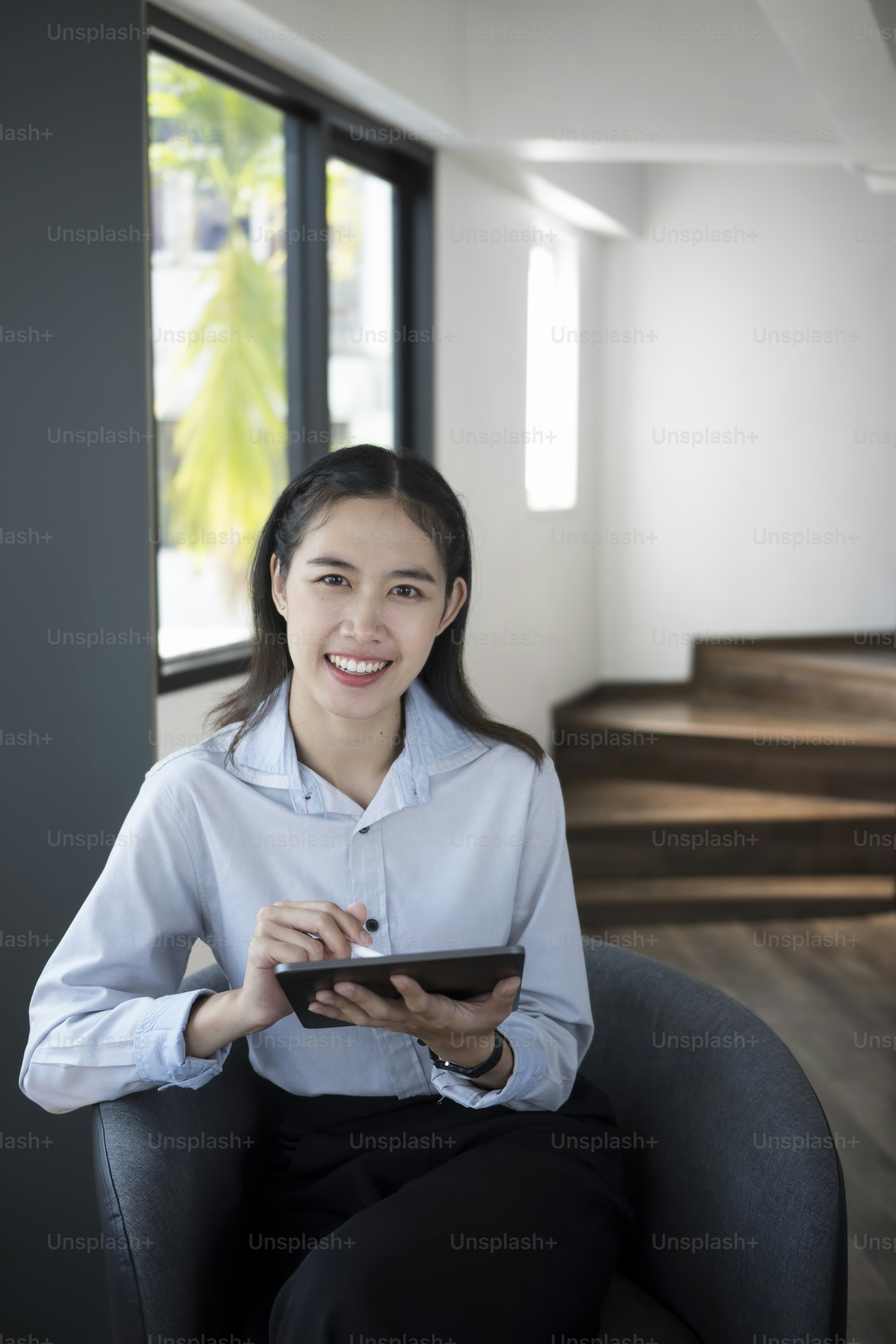 Happy woman office worker holding digital tablet and smiling to camera ...
