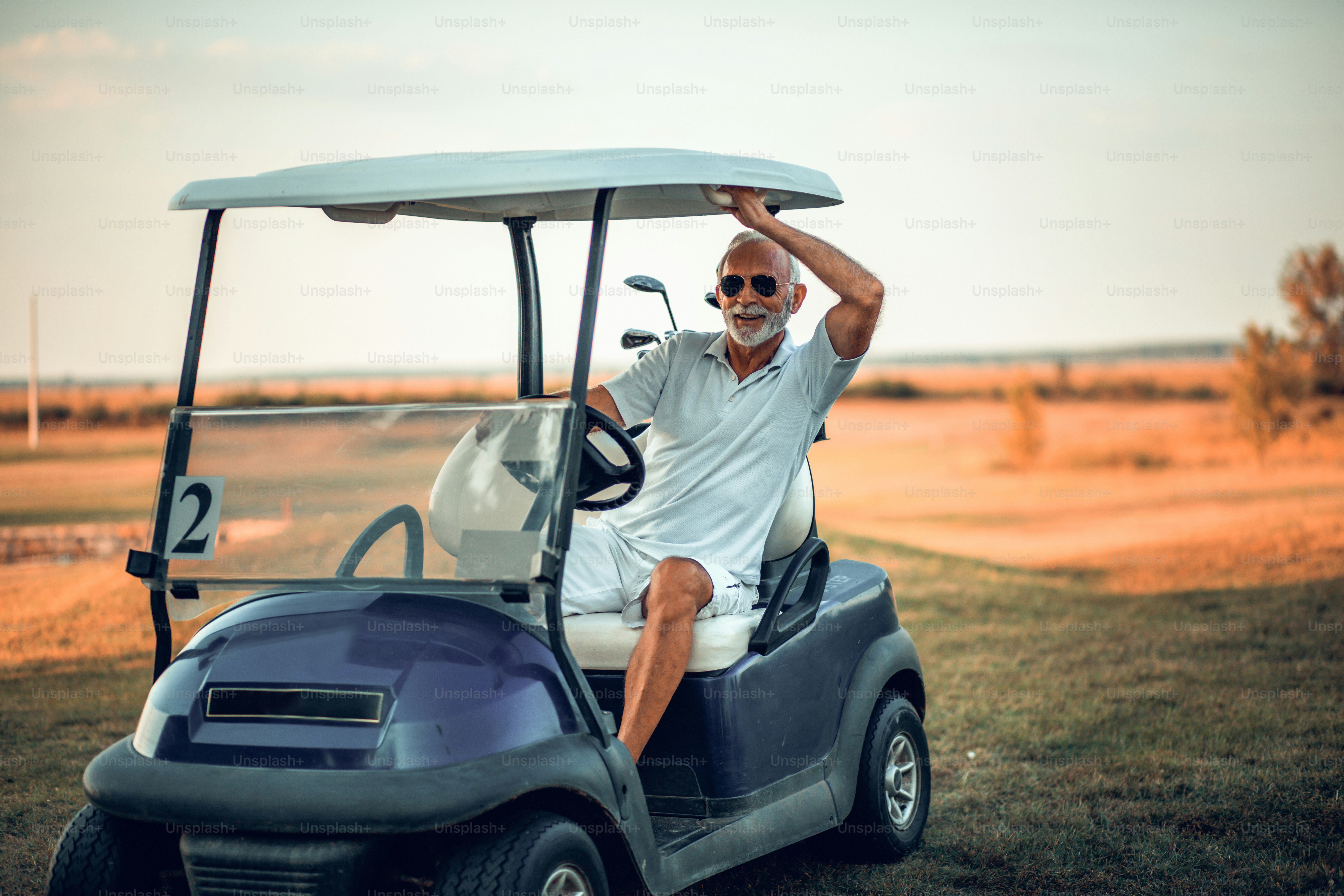 Senior man driving golf car. photo – Serbia Image on Unsplash