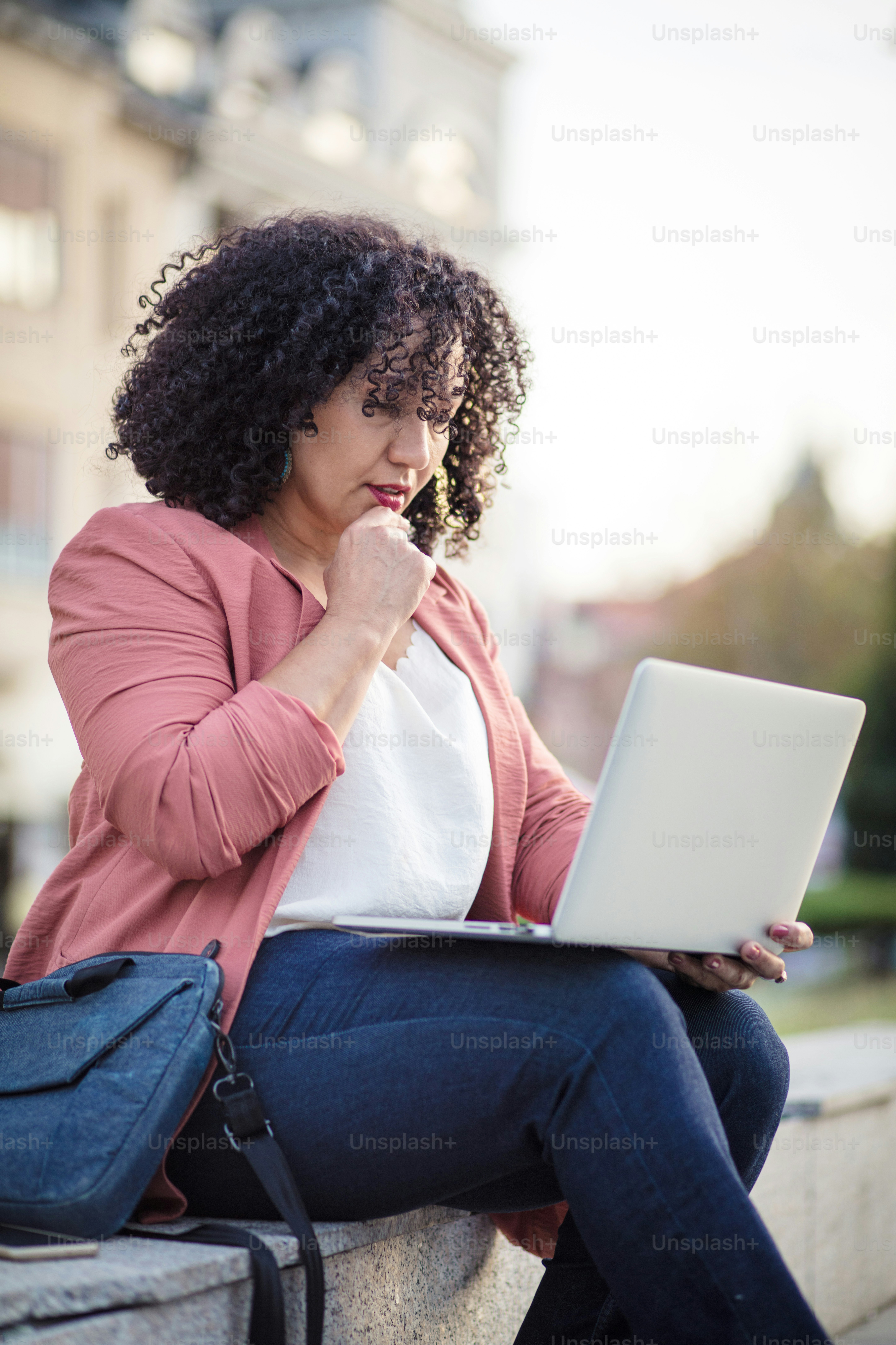 Business woman in the street using laptop. photo – Laptop Image on Unsplash