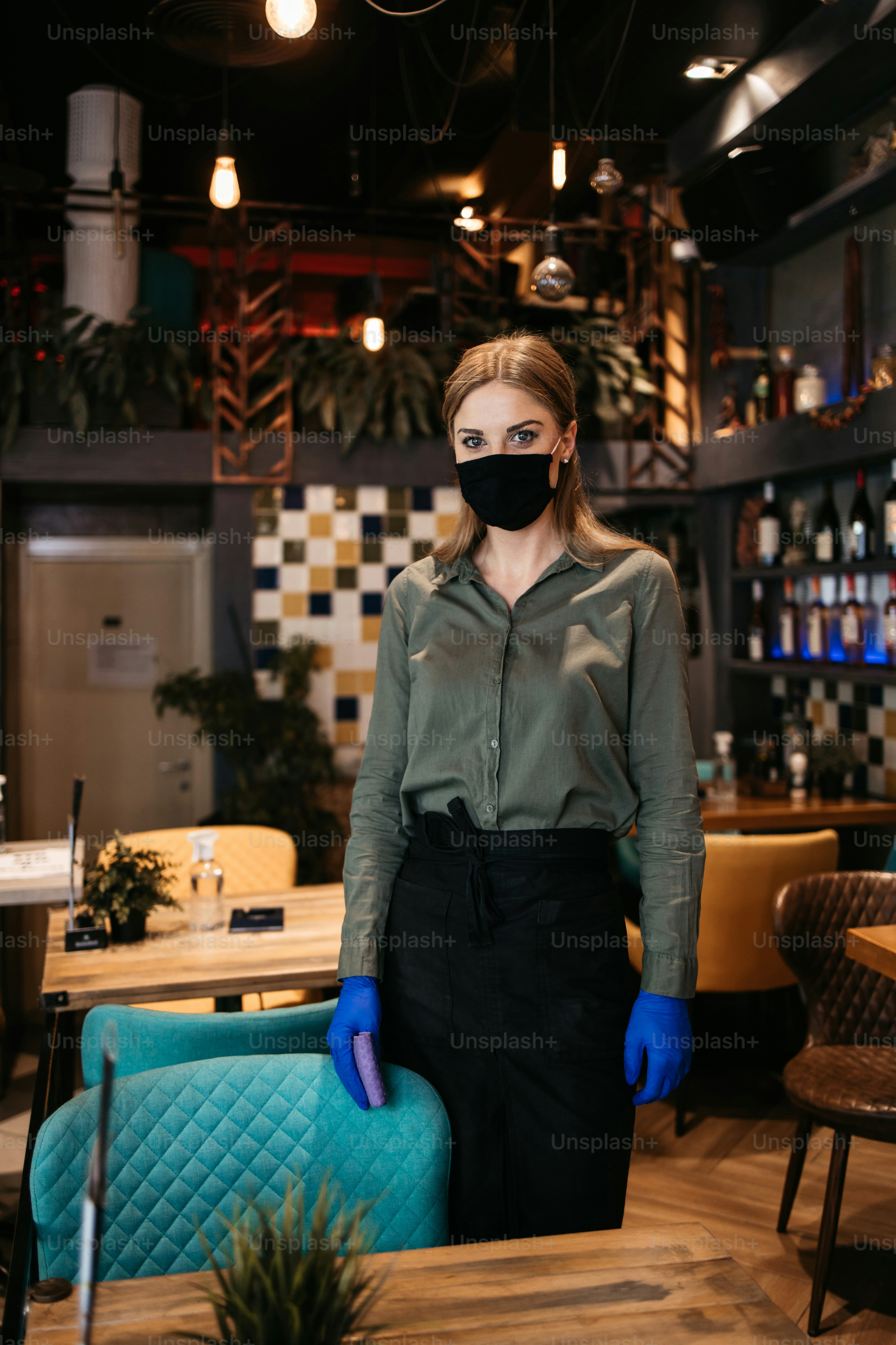 Portrait of a serious waitress standing behind a bar in a nice ...