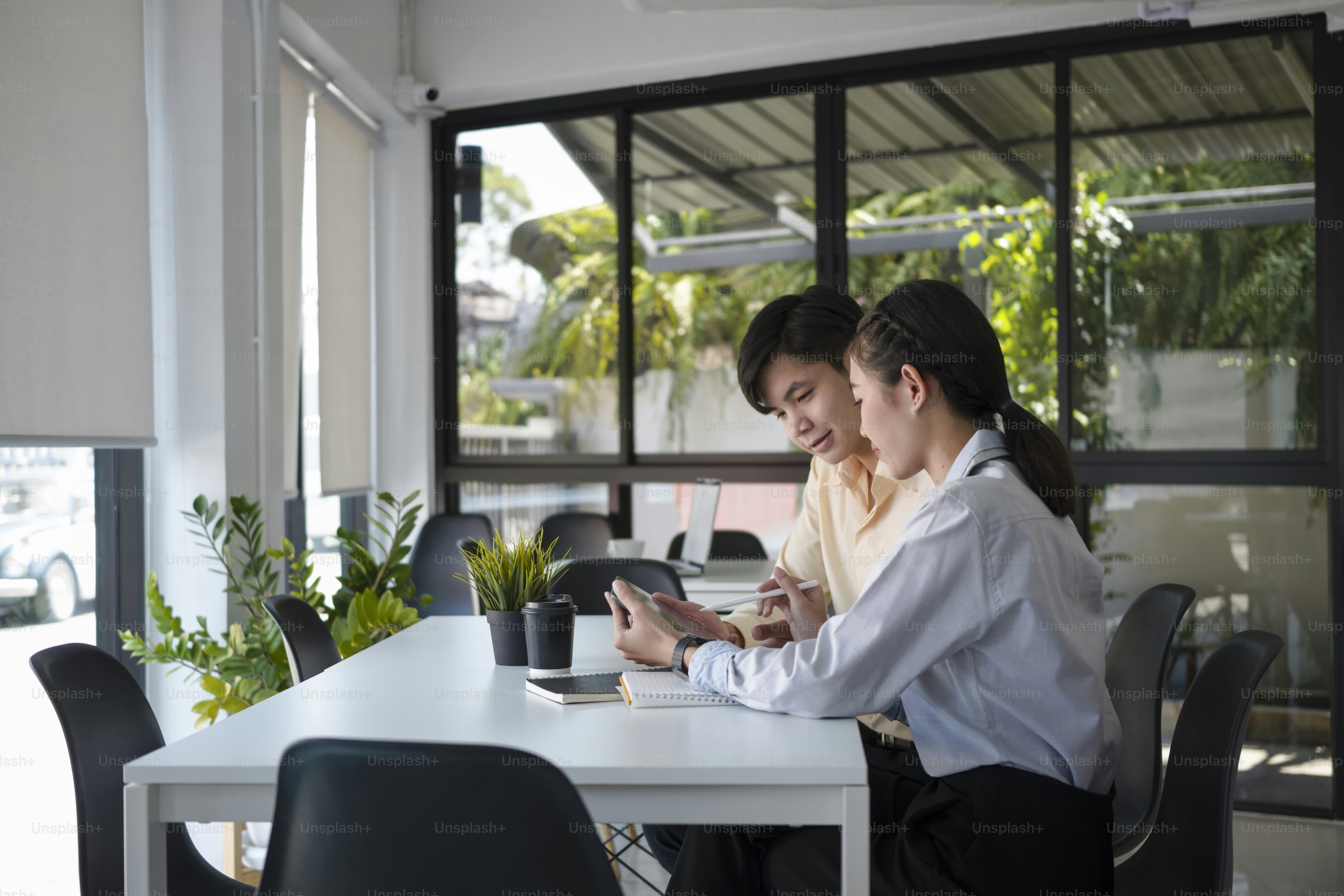 Two young business people talking project strategy at office. photo ...