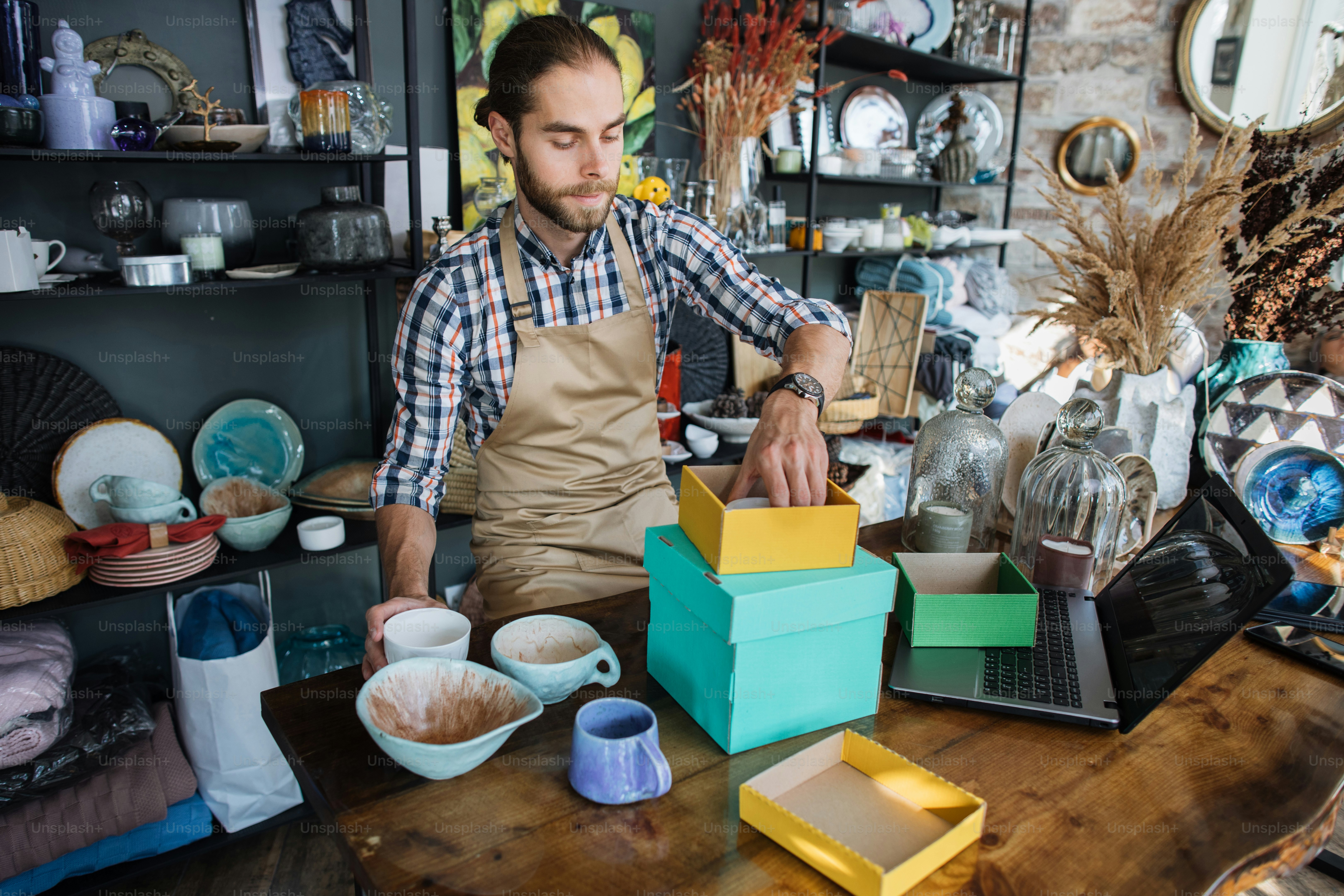 Handsome caucasian seller receiving unique goods at decor shop. Bearded ...