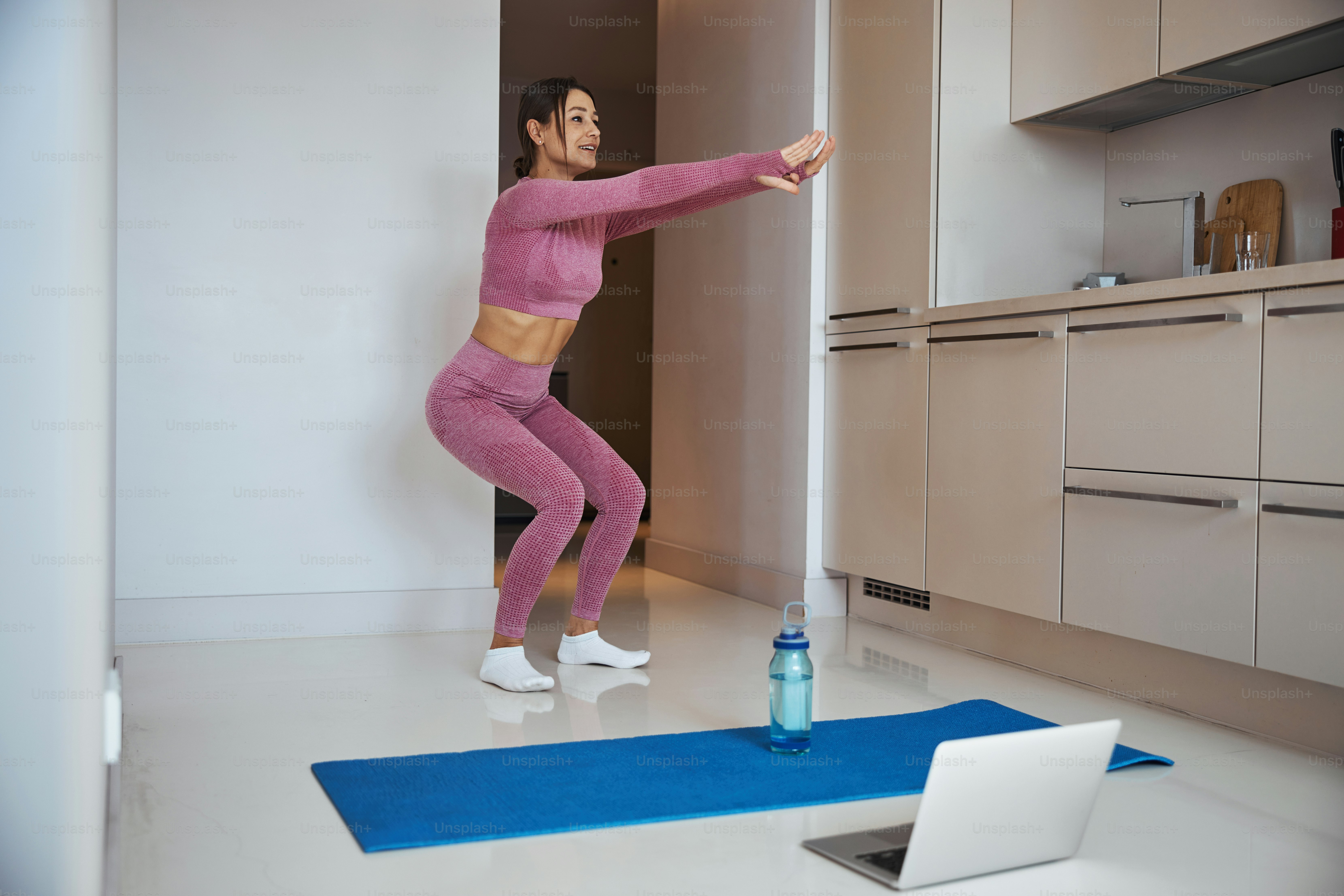 Beautiful sporty lady doing squats and smiling while having morning ...