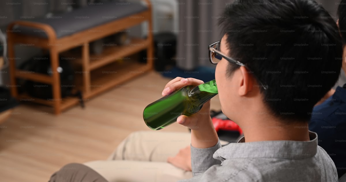 Foto Dos Jóvenes Bebiendo Cerveza Y Viendo Un Partido De Fútbol En Casa
