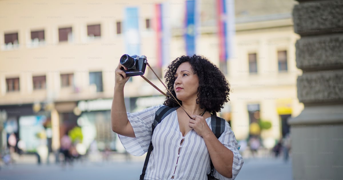 通りに立って写真を撮る女性。街で写真を撮る女性。の写真 写真家 Unsplashの写真