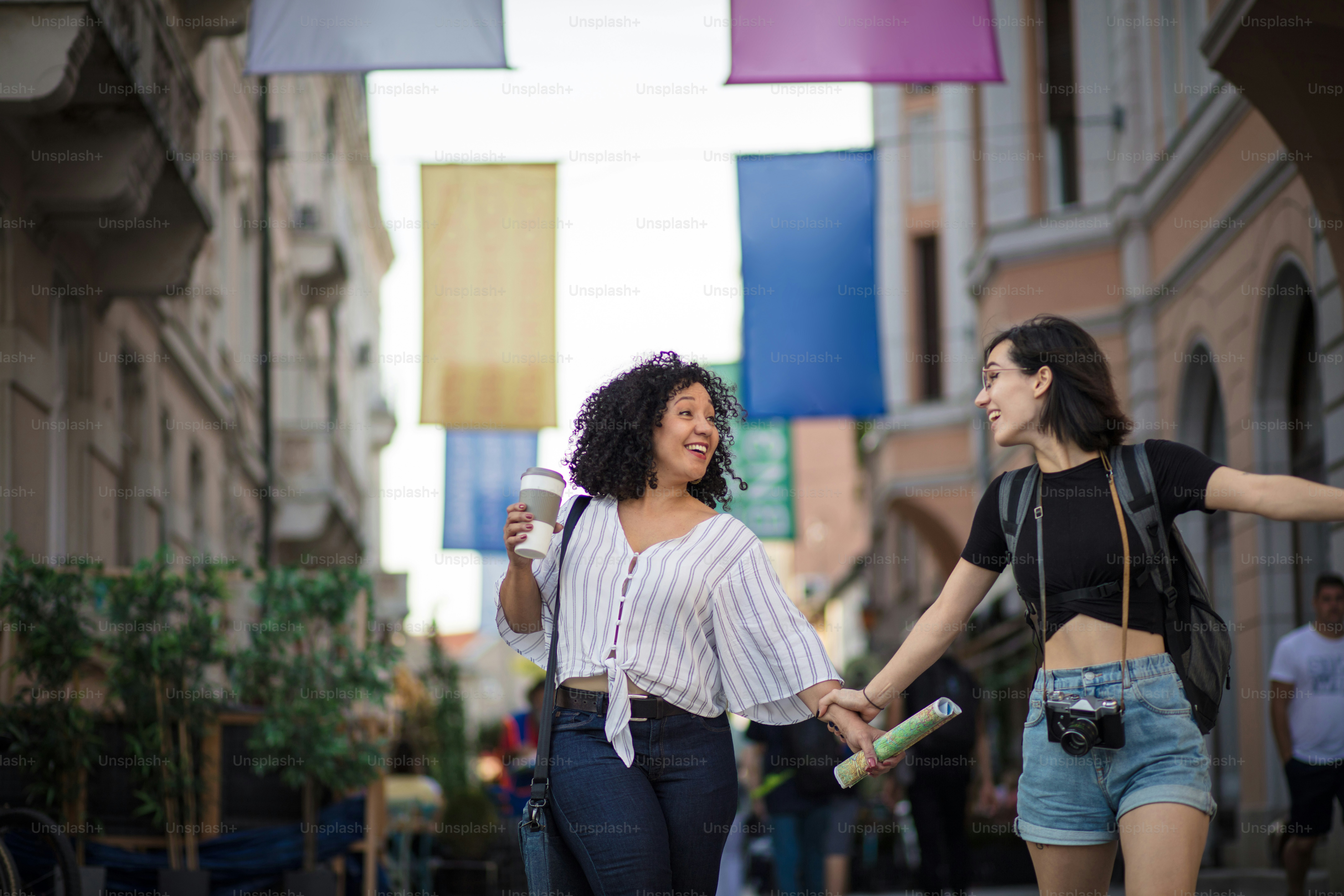 Great city for adventure. Two tourist women on street. photo – African ...