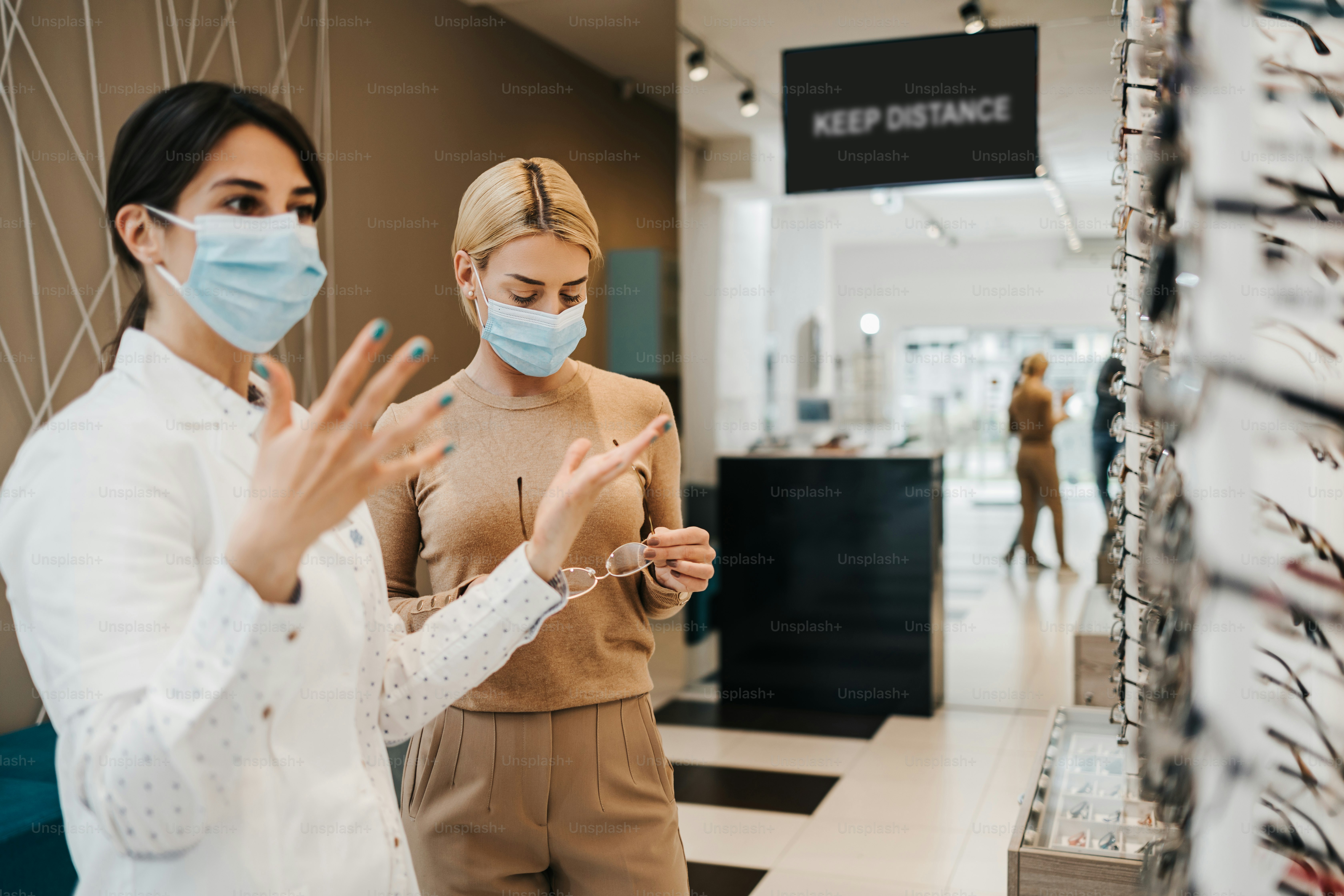 Beautiful and fashionable woman choosing eyeglasses frame in modern ...