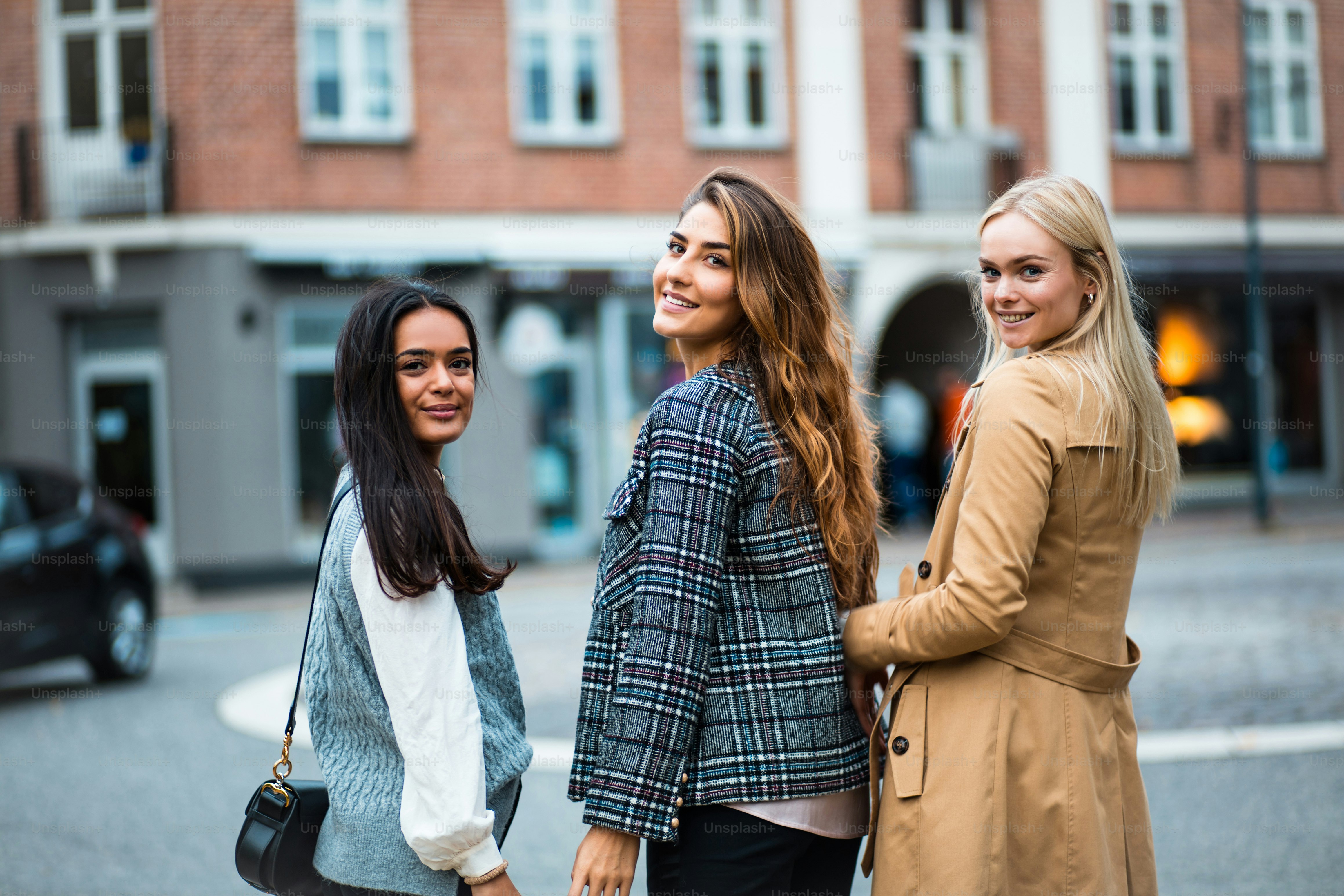 Portrait of three women standing on street and looking at camera. photo ...