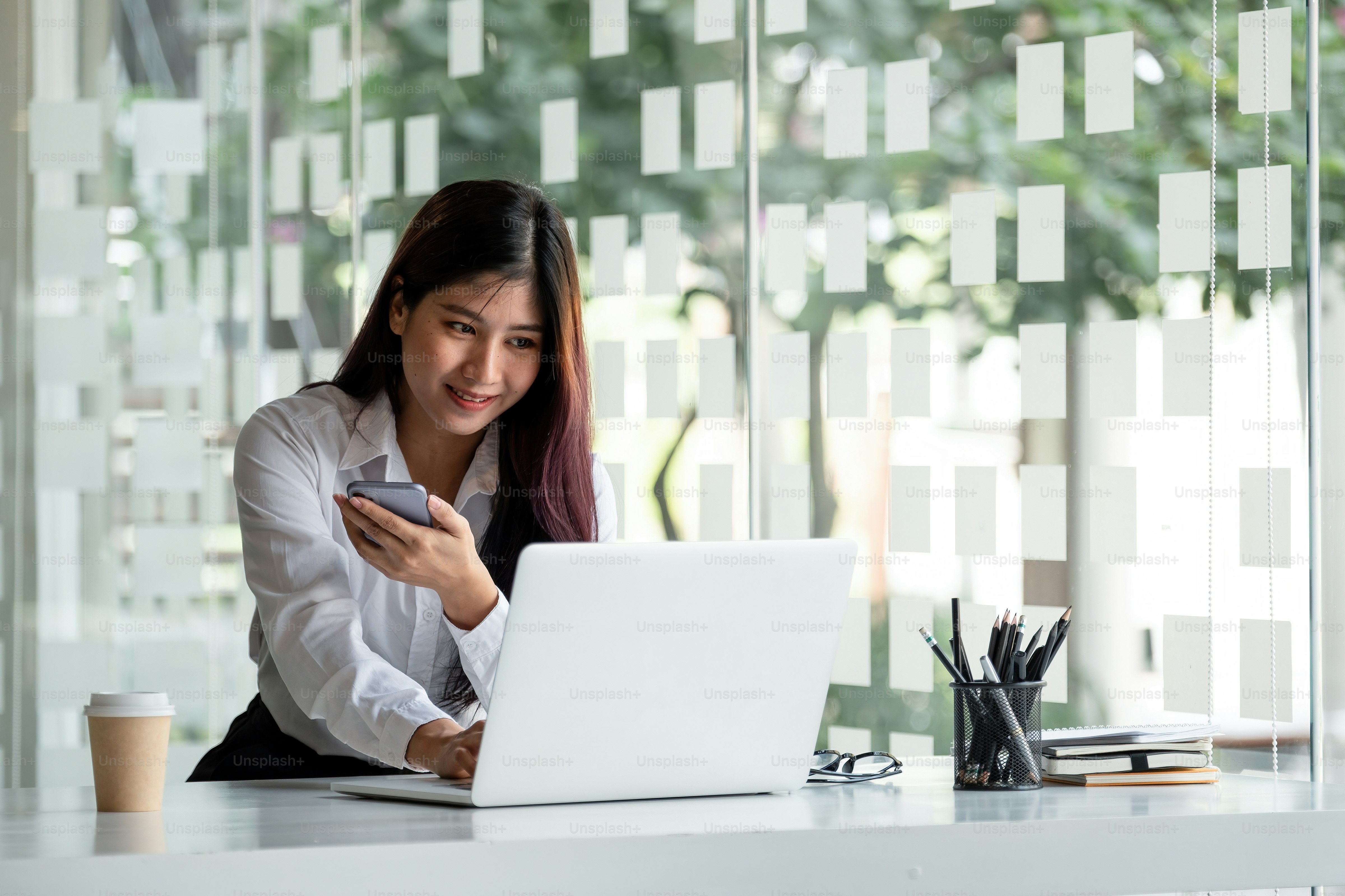 Woman using laptop computer and smartphone for online education at home ...