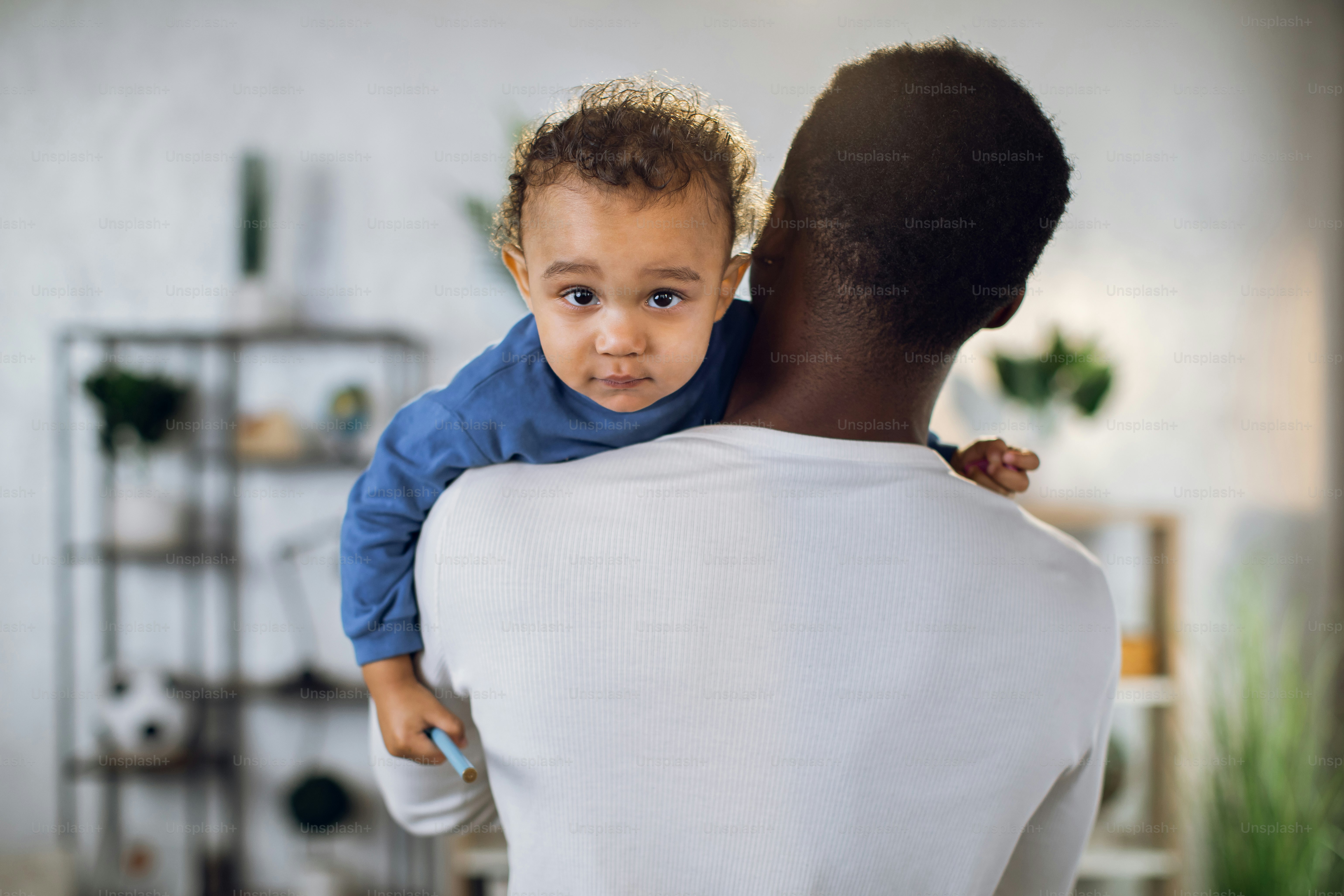 Back view of african father holding cute little son on hands that ...
