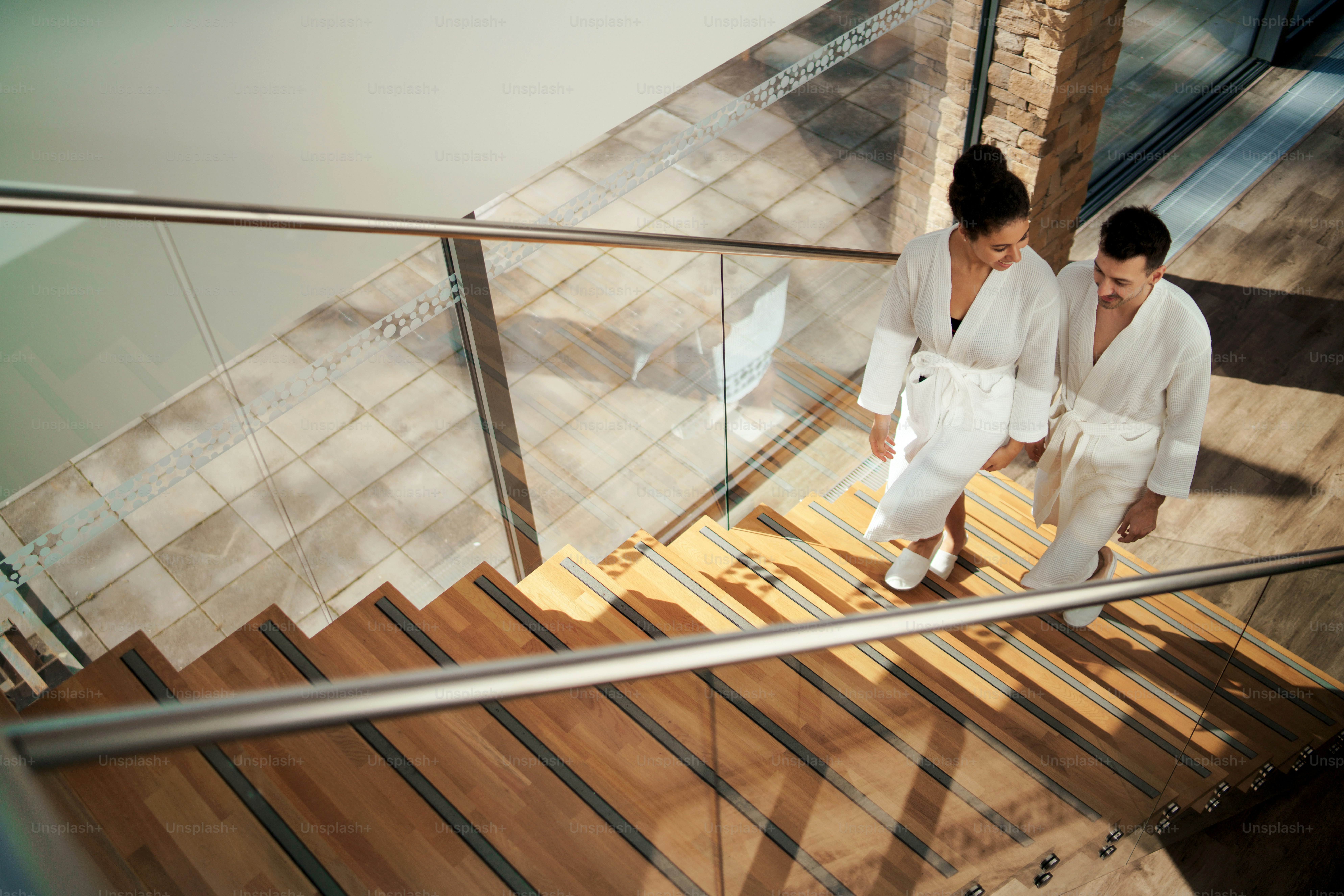A top view of happy young couple in spa resort, walking up the stairs ...
