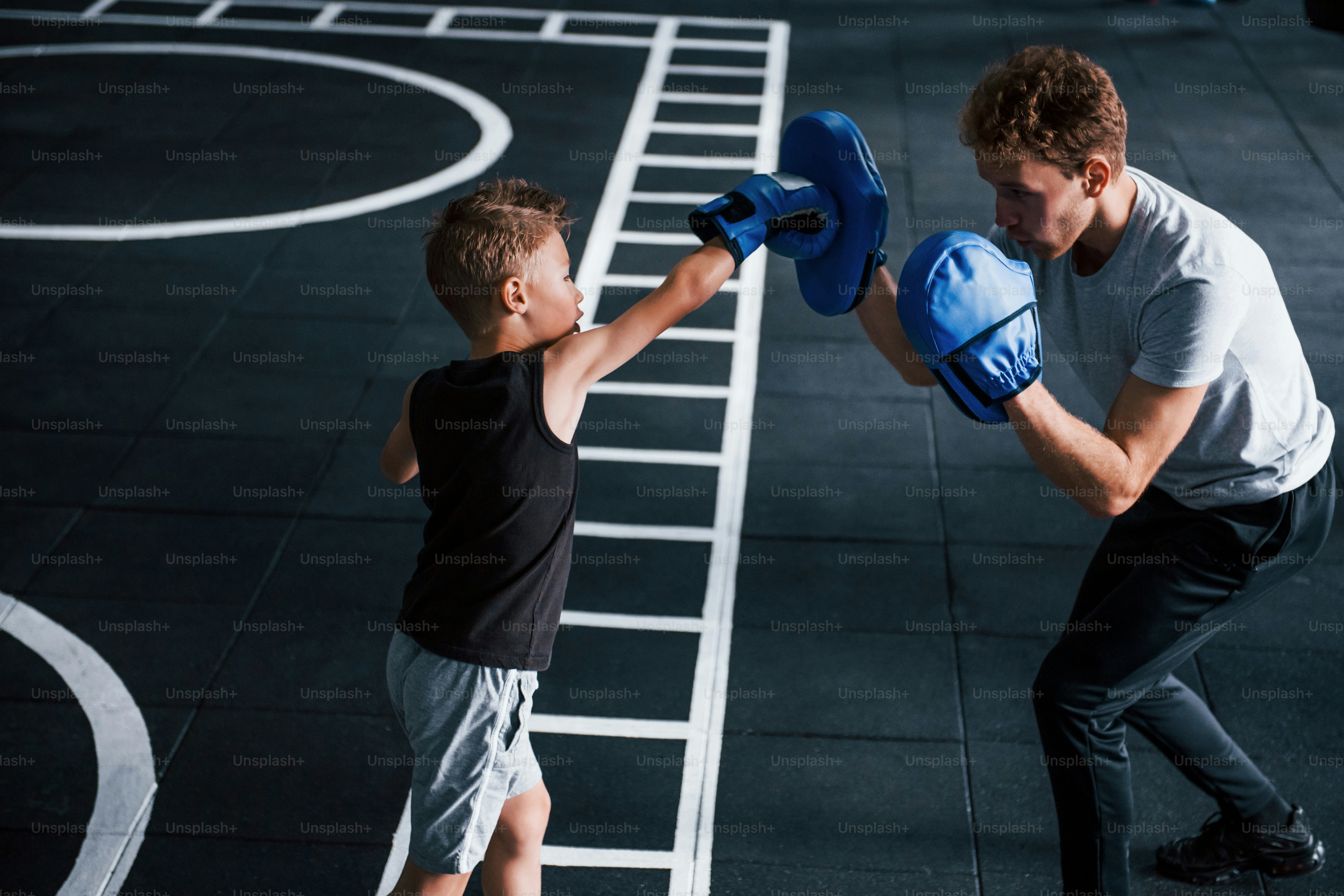 Young trainer teaches kid boxing sport in the gym. photo – Healthy ...