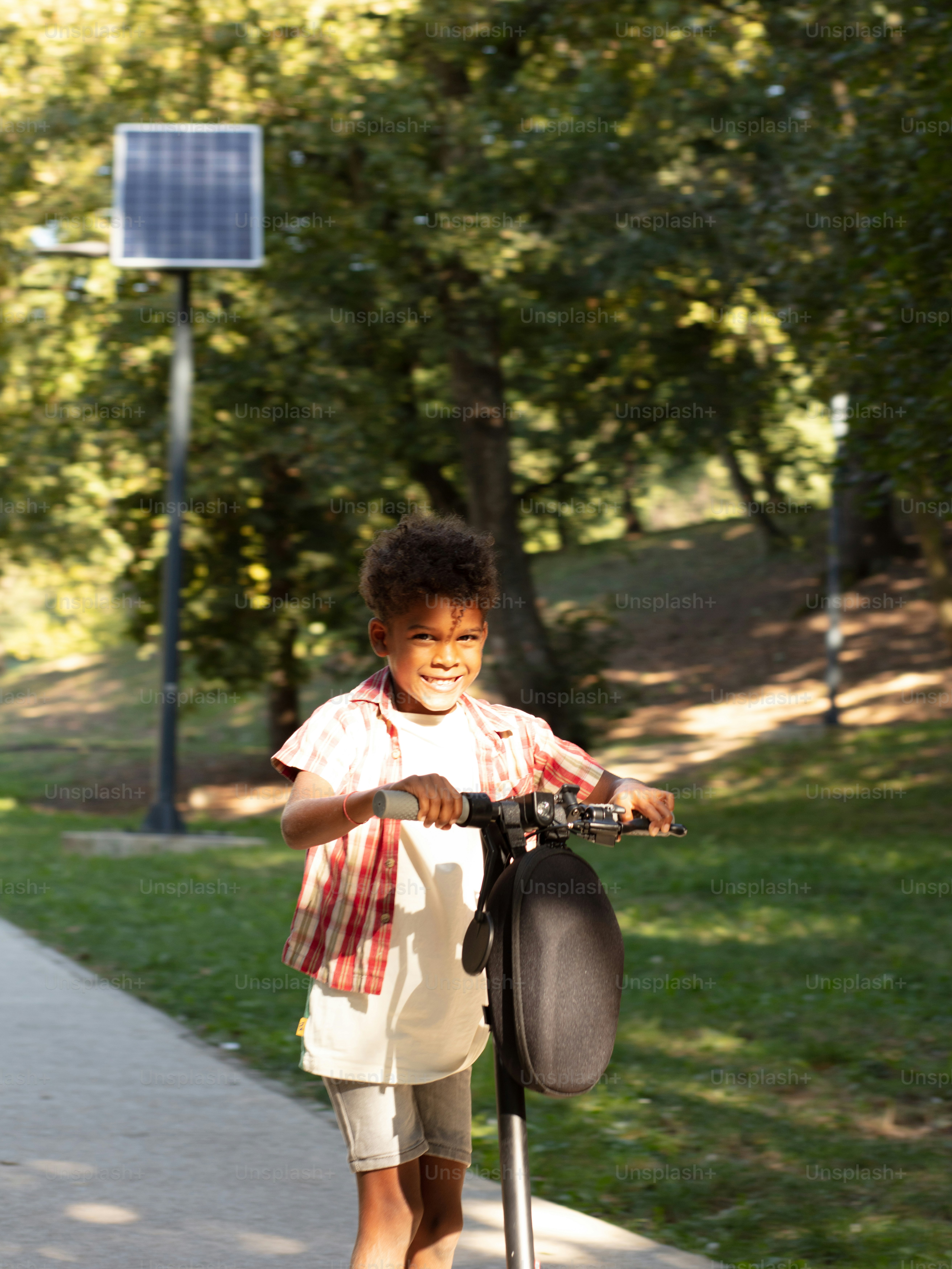 Niño sonriente conduciendo scooter eléctrico. foto – Imagen de Muchacho ...