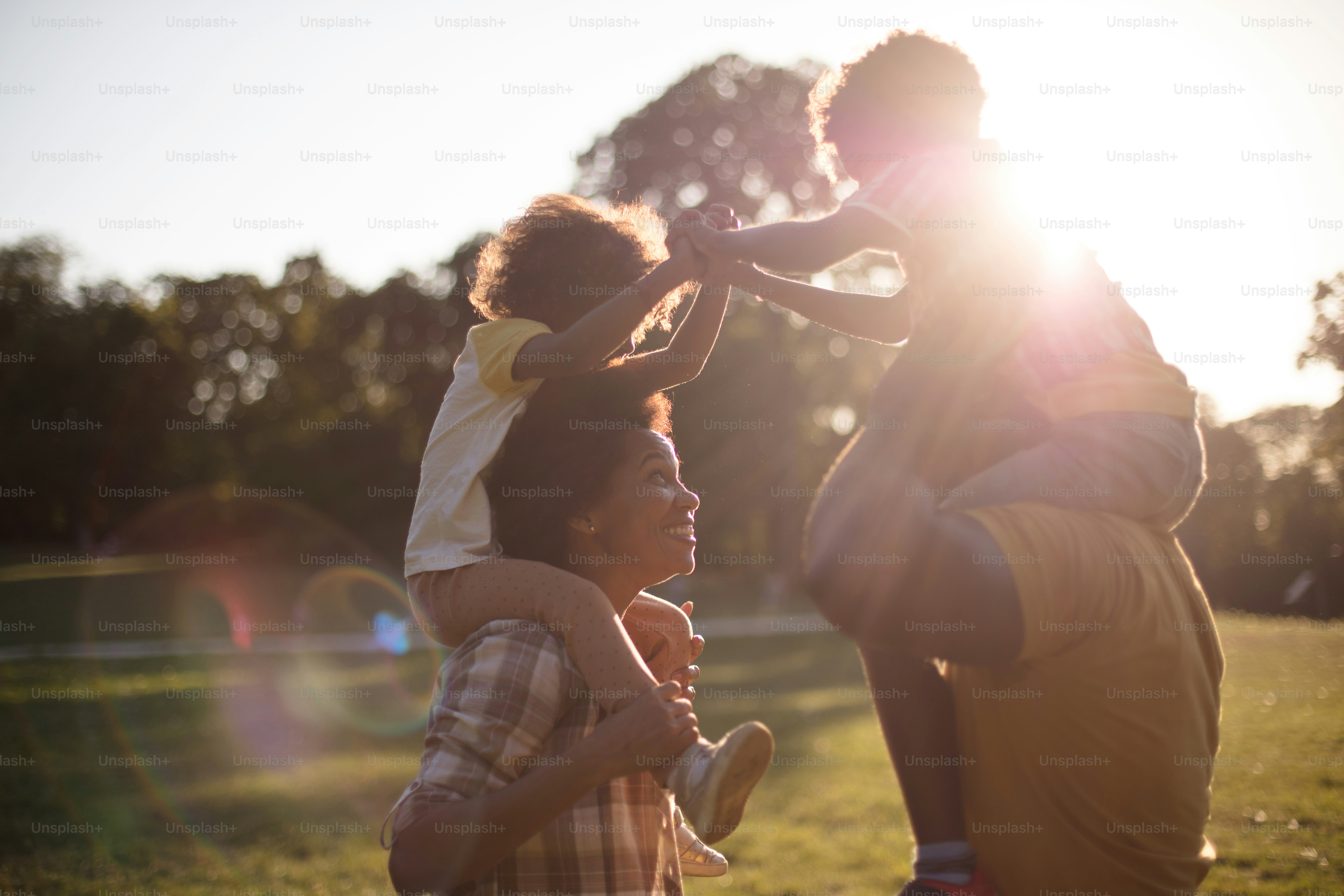 Great autumn day for fun. African American family having fun outdoors ...