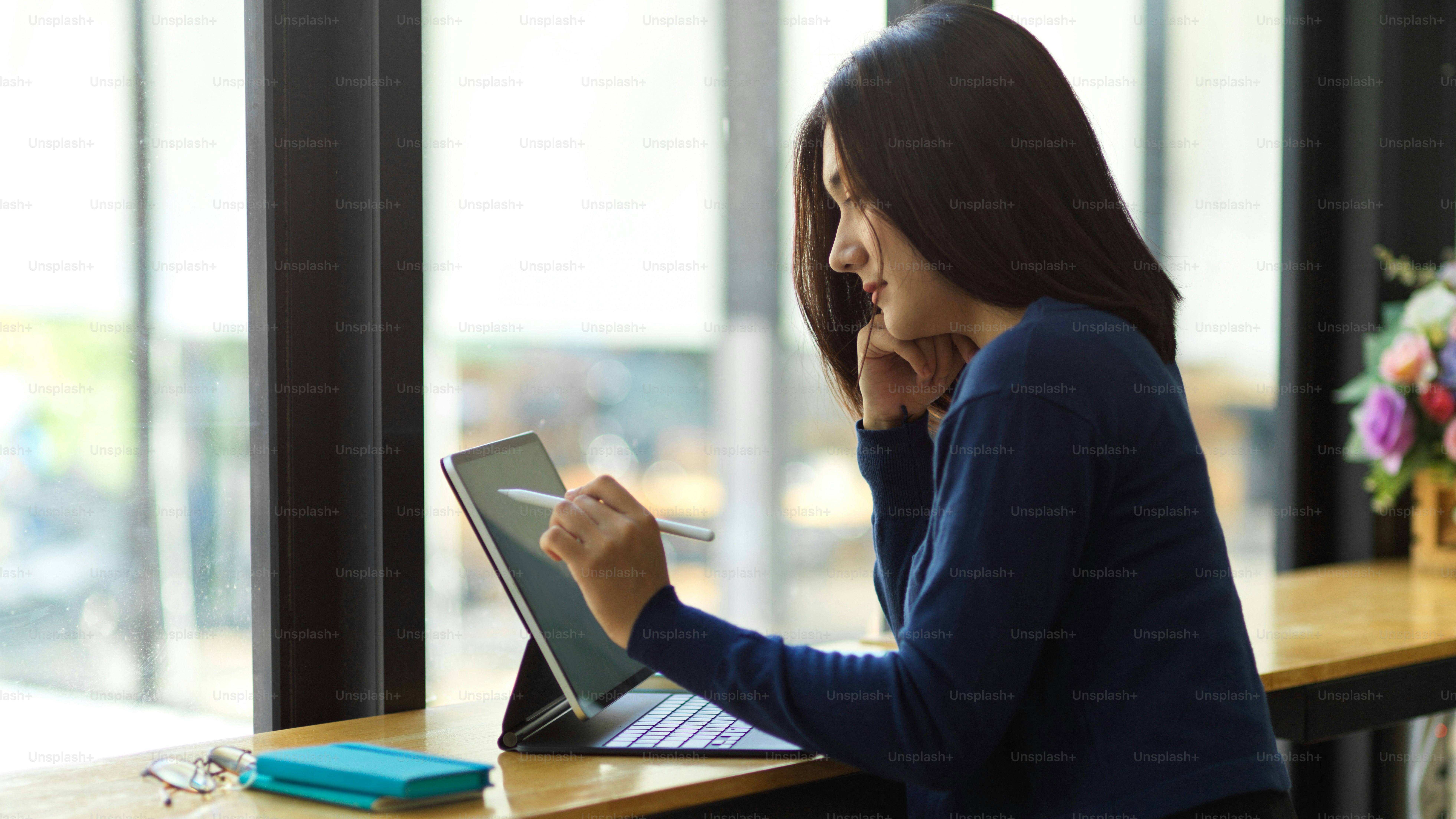 Side view of female teenager using digital tablet with stylus and ...