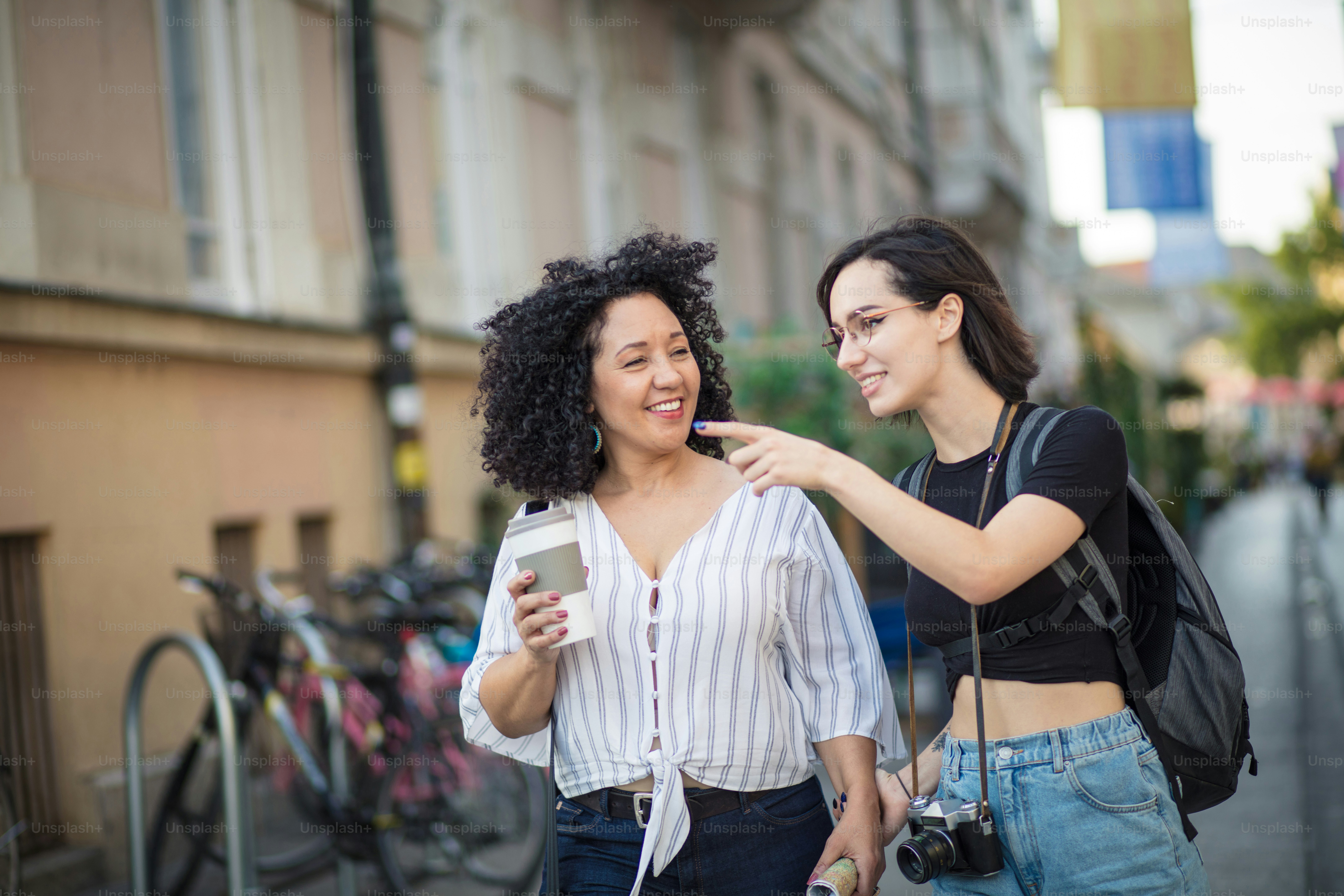 Talk and walk trough city. Two tourist women on street. photo – Travel ...
