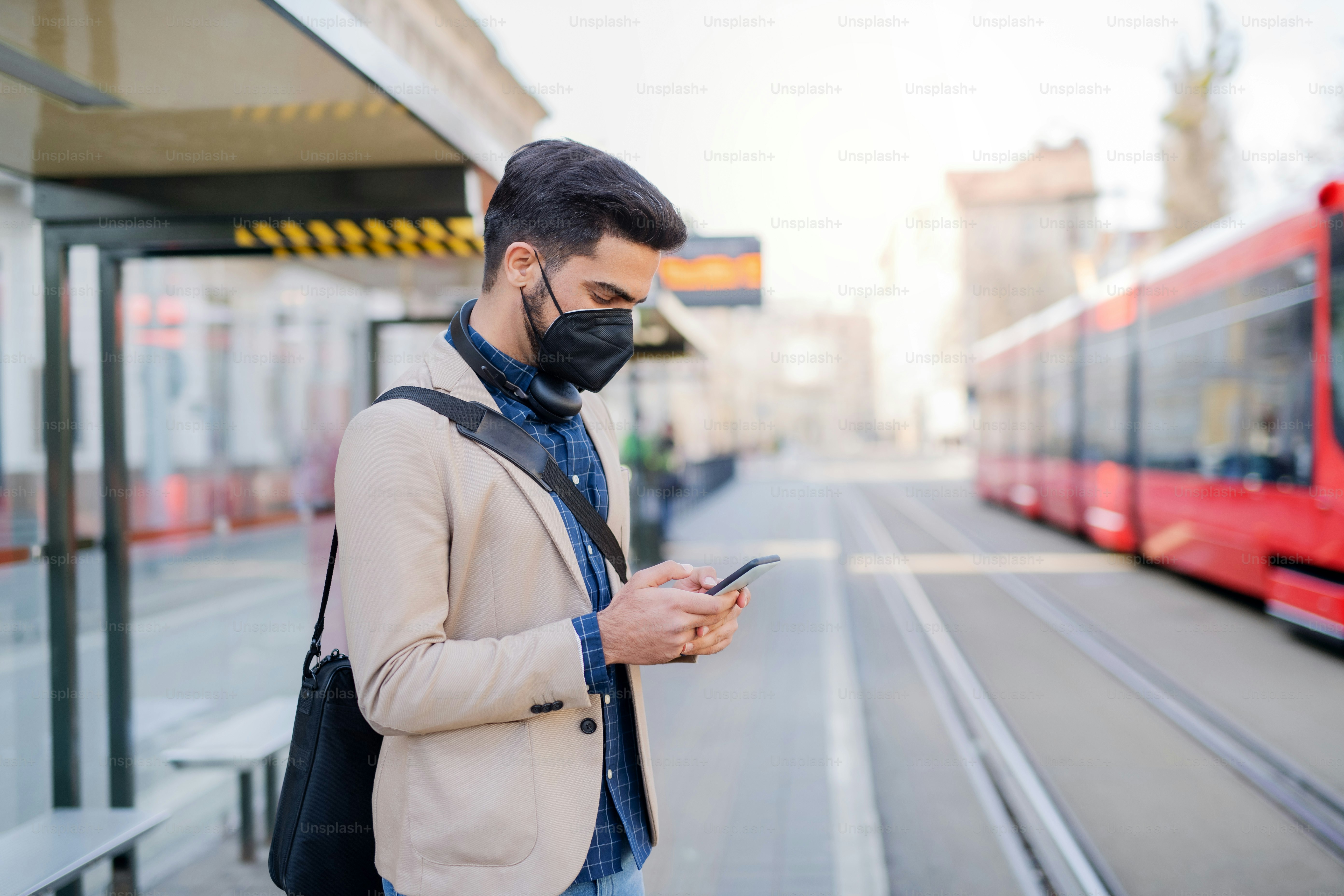 A young business man commuter with smartphone on the way to work ...