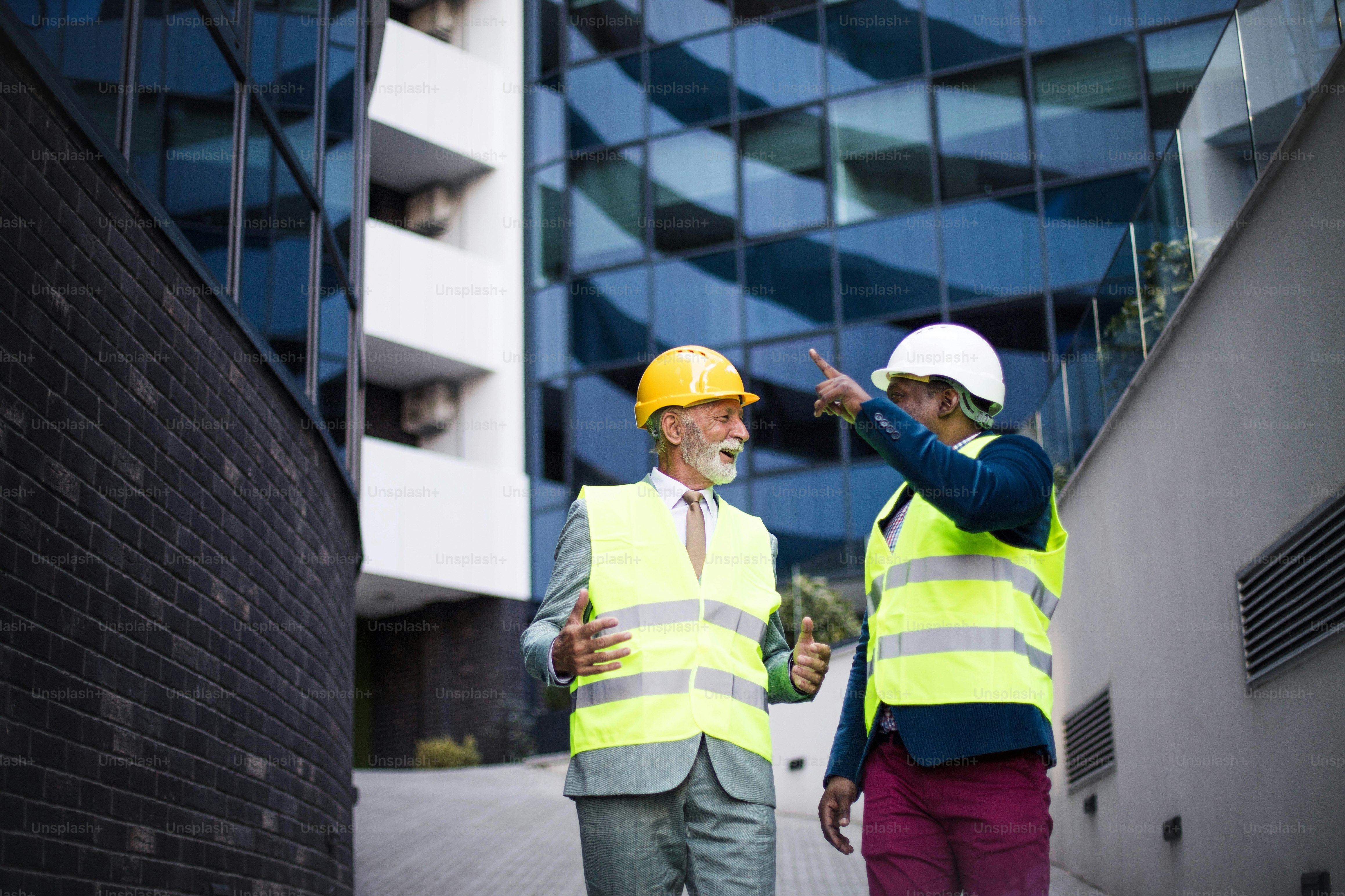Mature engineer discussing the structure of the building with ...