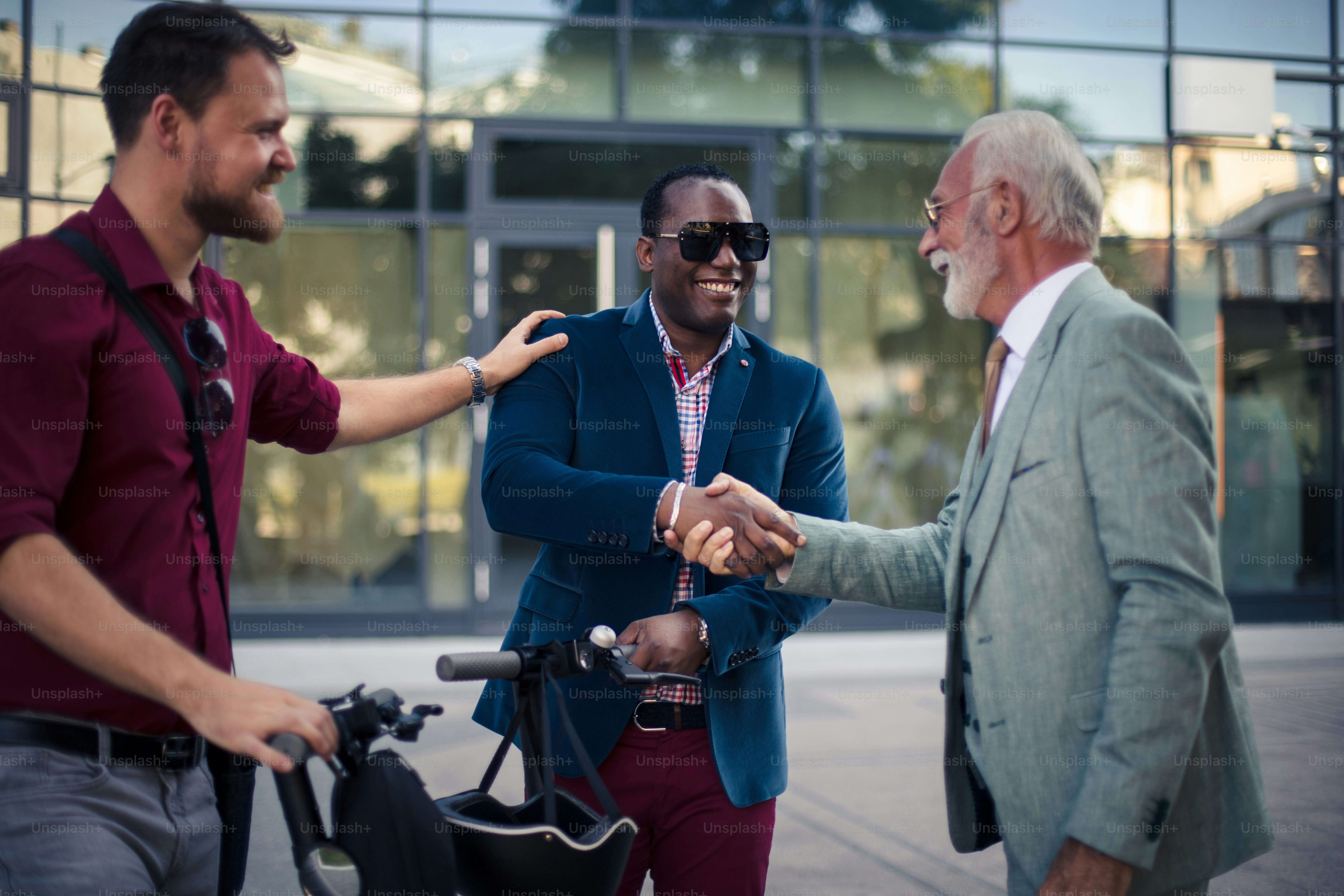 Three business colleagues standing outdoors and discussing. Small Group ...