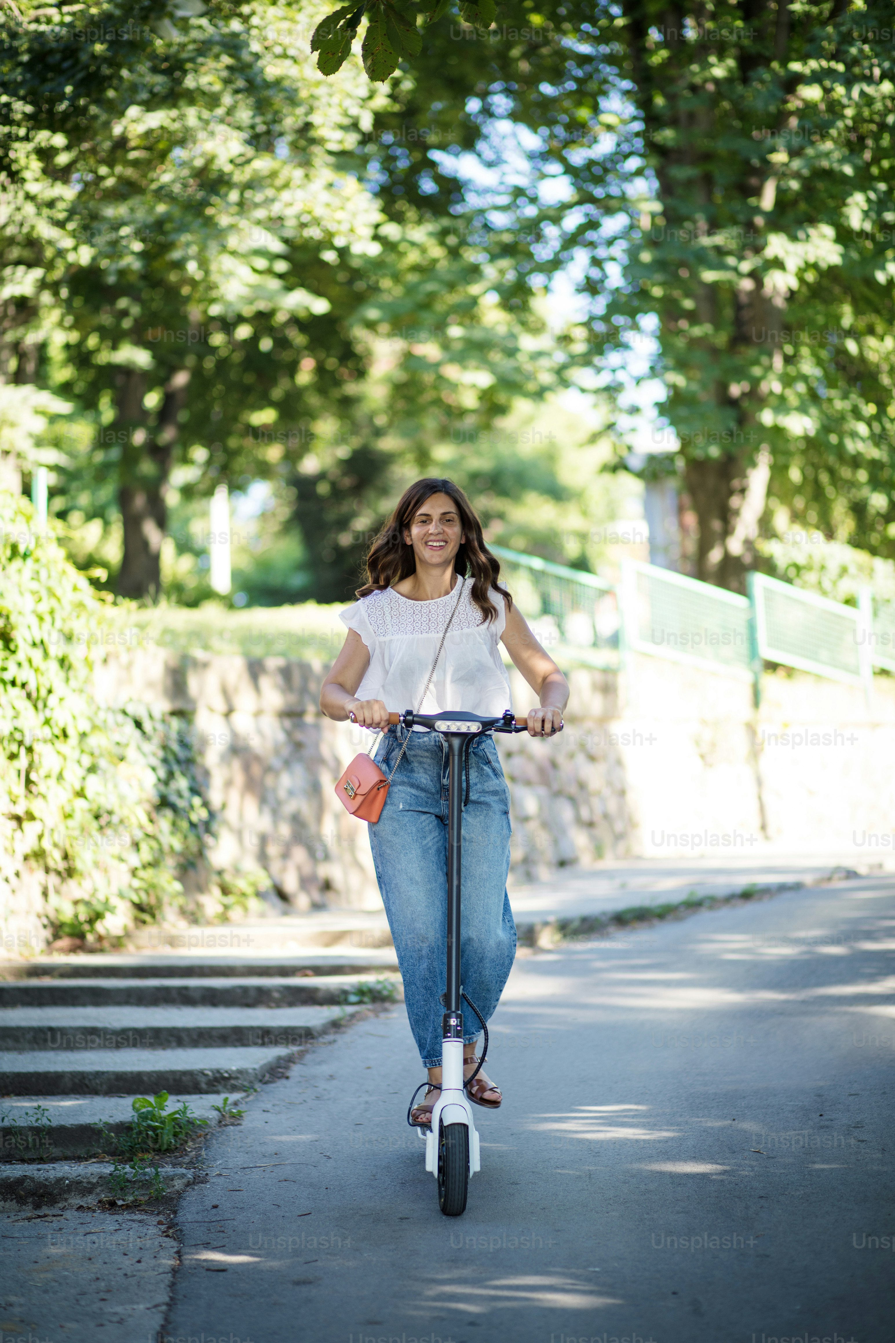 Enjoy every day of your life. Woman riding scooter at the park. photo ...