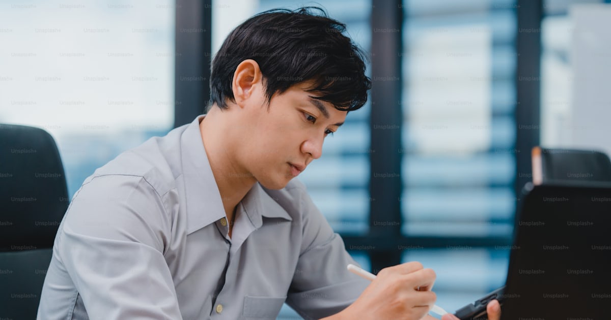 성공적인 임원 아시아 젊은 사업가 스마트 캐주얼웨어 드로잉 쓰기 및 디지털 태블릿 컴퓨터로 펜을 사용하여 현대 사무실에서 영감
