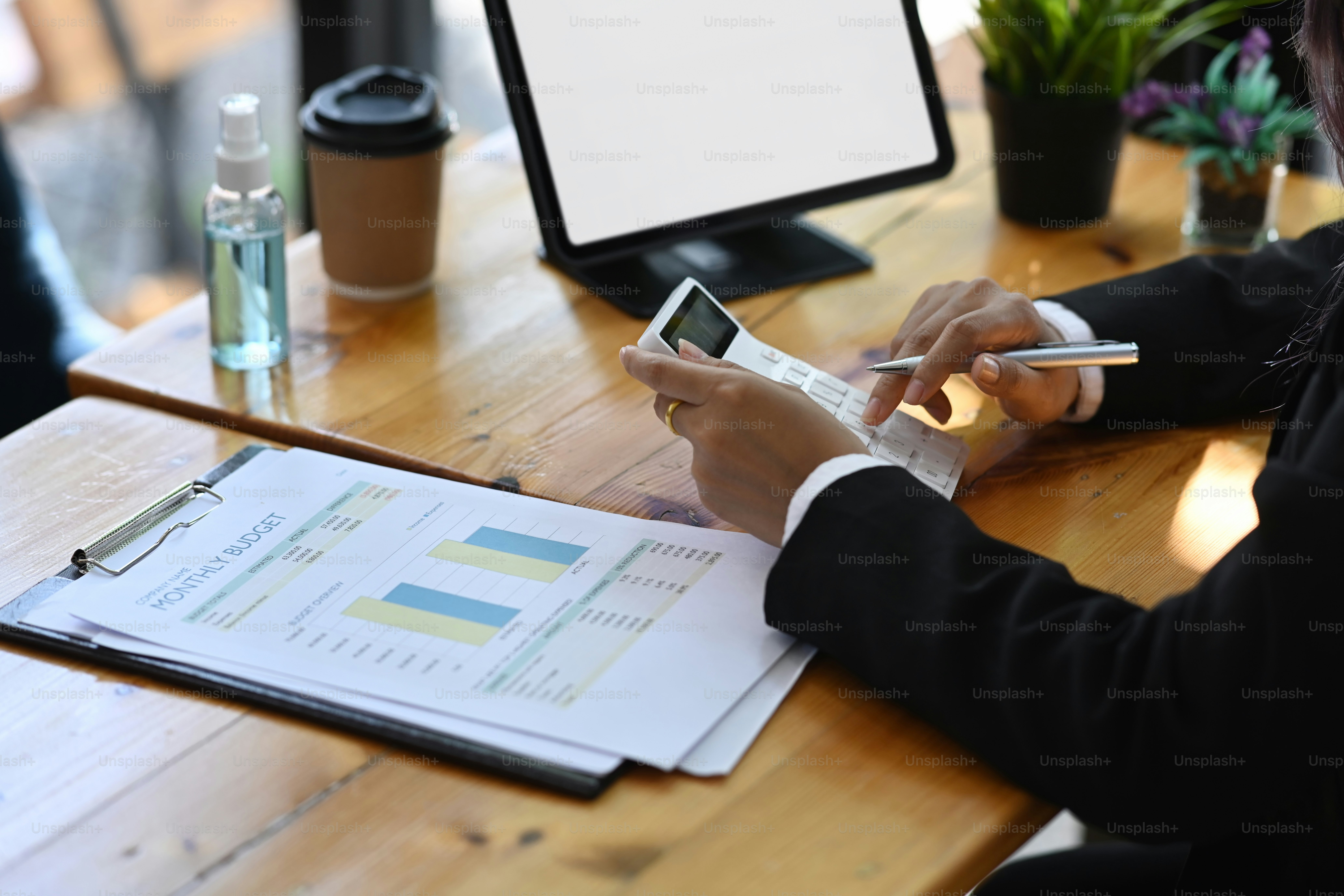 Accountant using calculator and working with computer tablet at modern ...