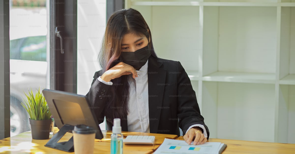 사무실에서 디지털 태블릿과 서류 작업을 하는 얼굴 마스크를 쓴 사업가의 절반 길이 초상화 사진 Unsplash의 테이블 이미지