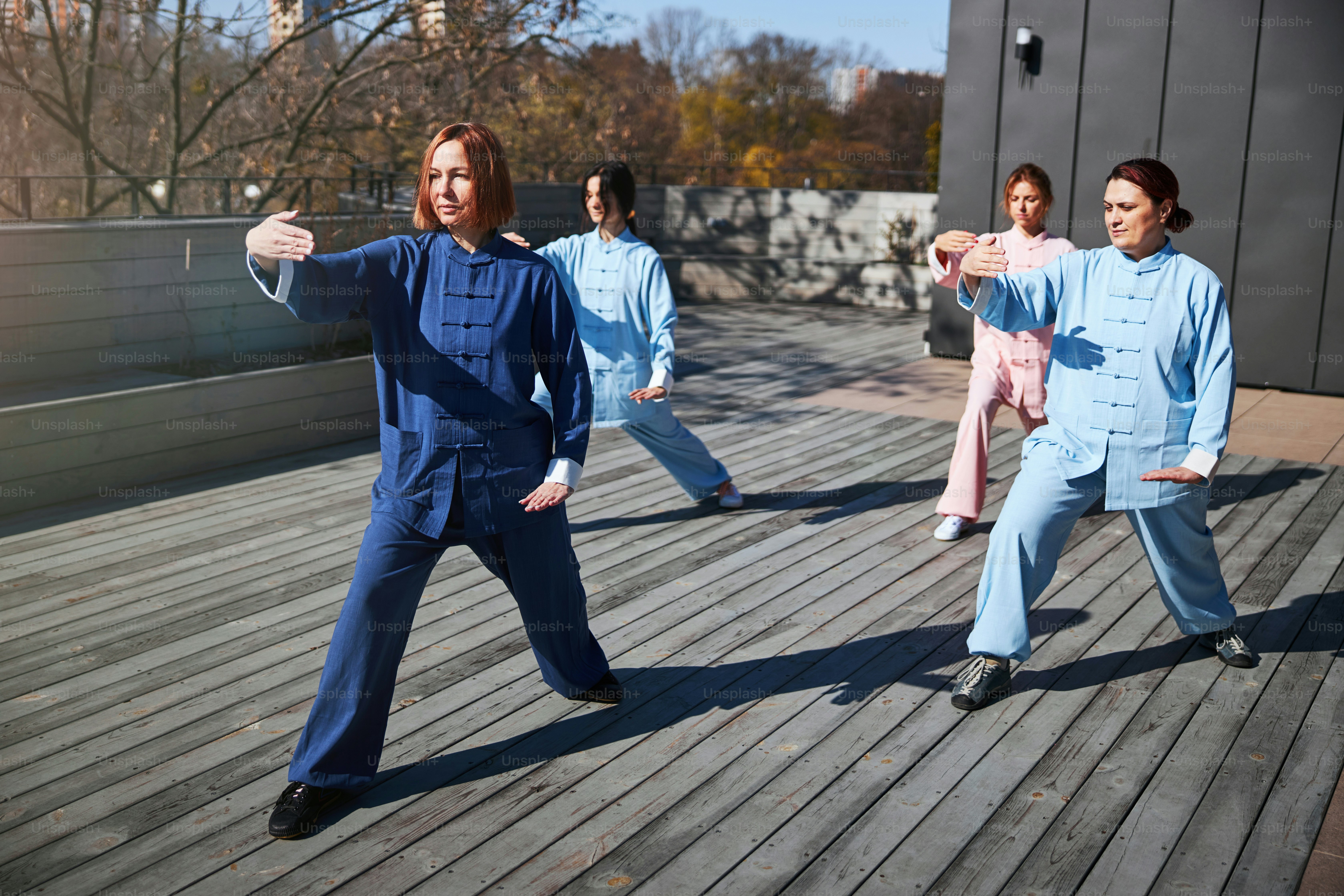 Three women working with their master and practicing qigong outdoors on ...