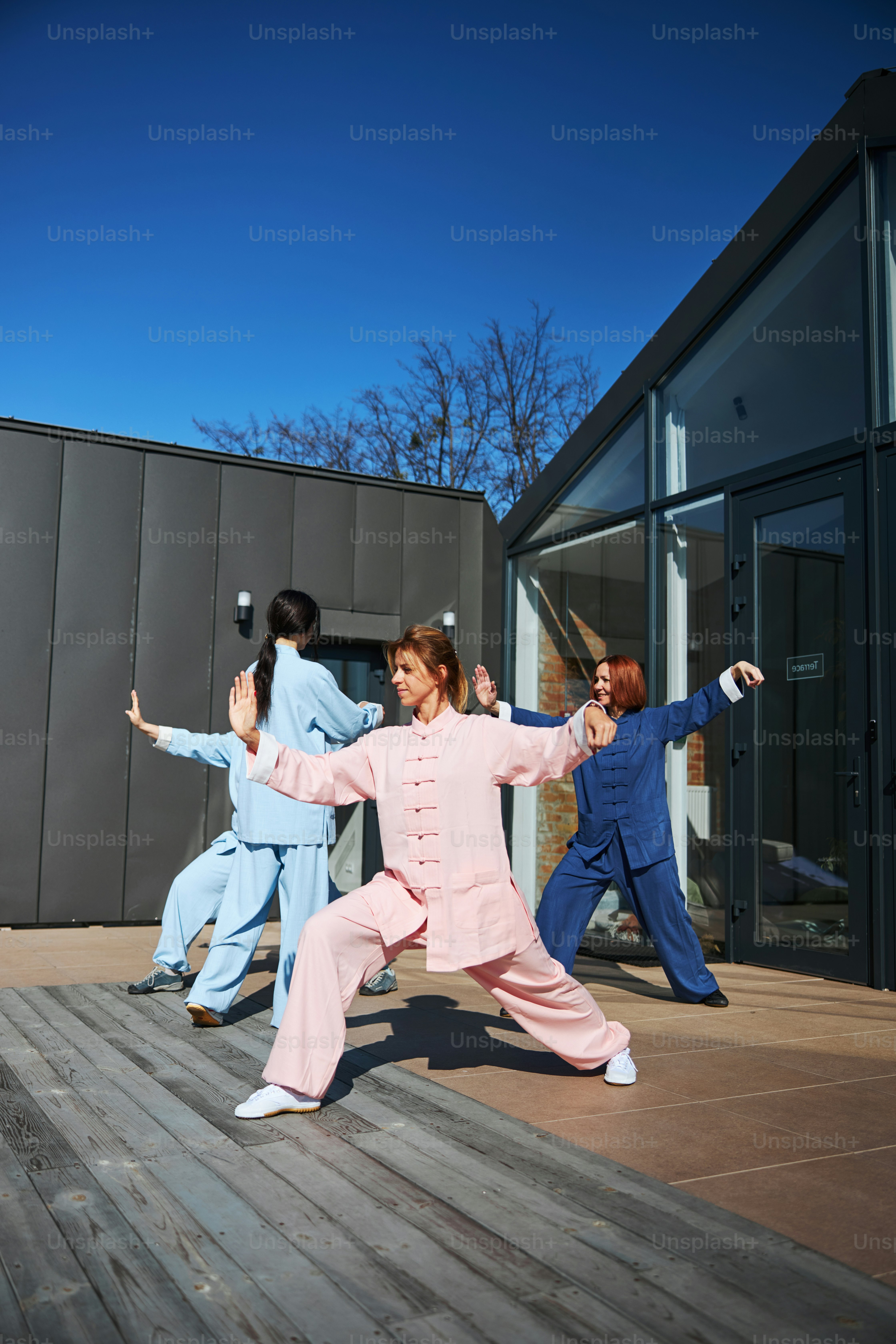 Female group of qigong followers doing physical exercises with their ...