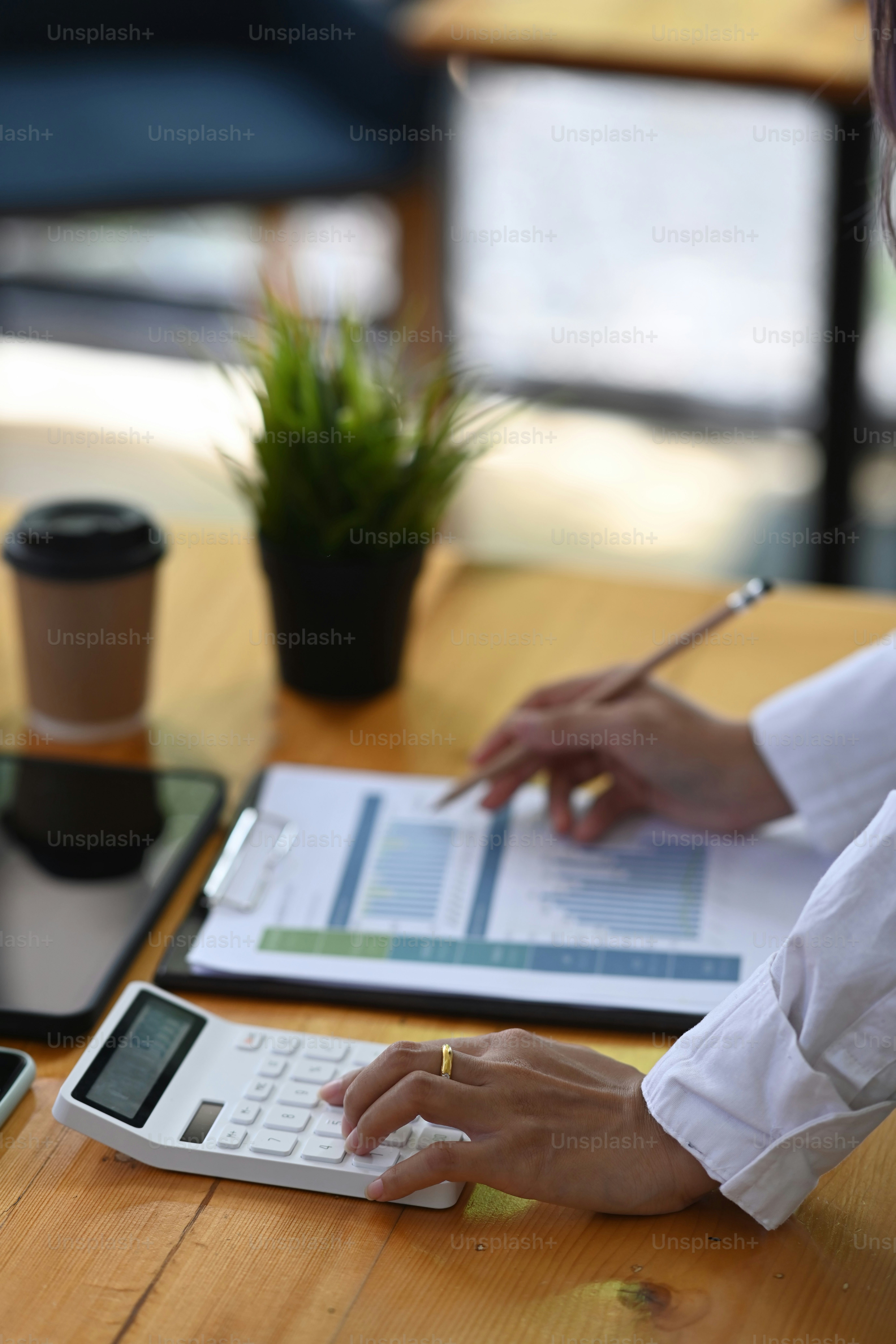 Accountant using calculator and analyzing financial graph on office ...