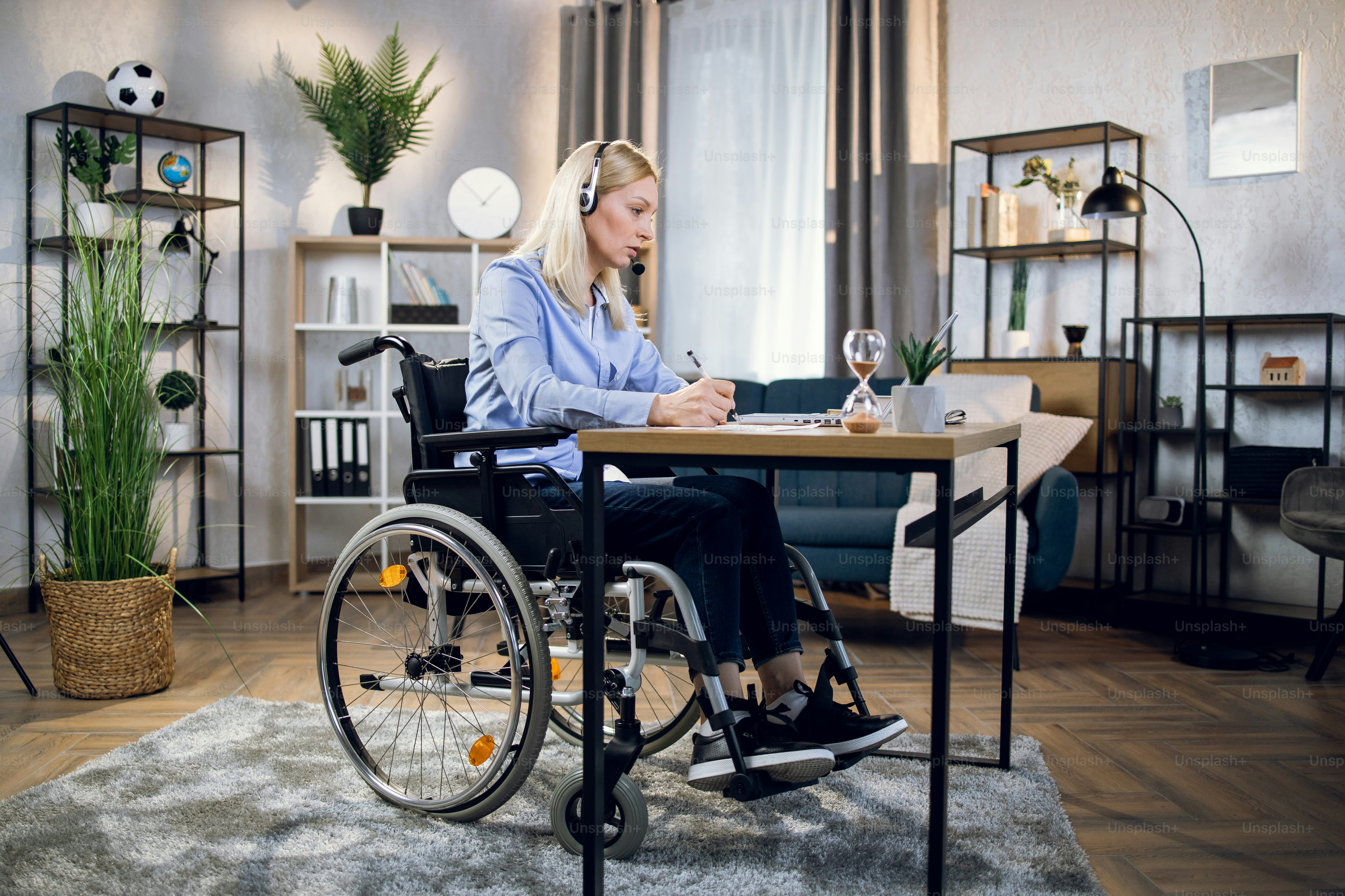 Side view of woman with disabilities taking notes during video ...