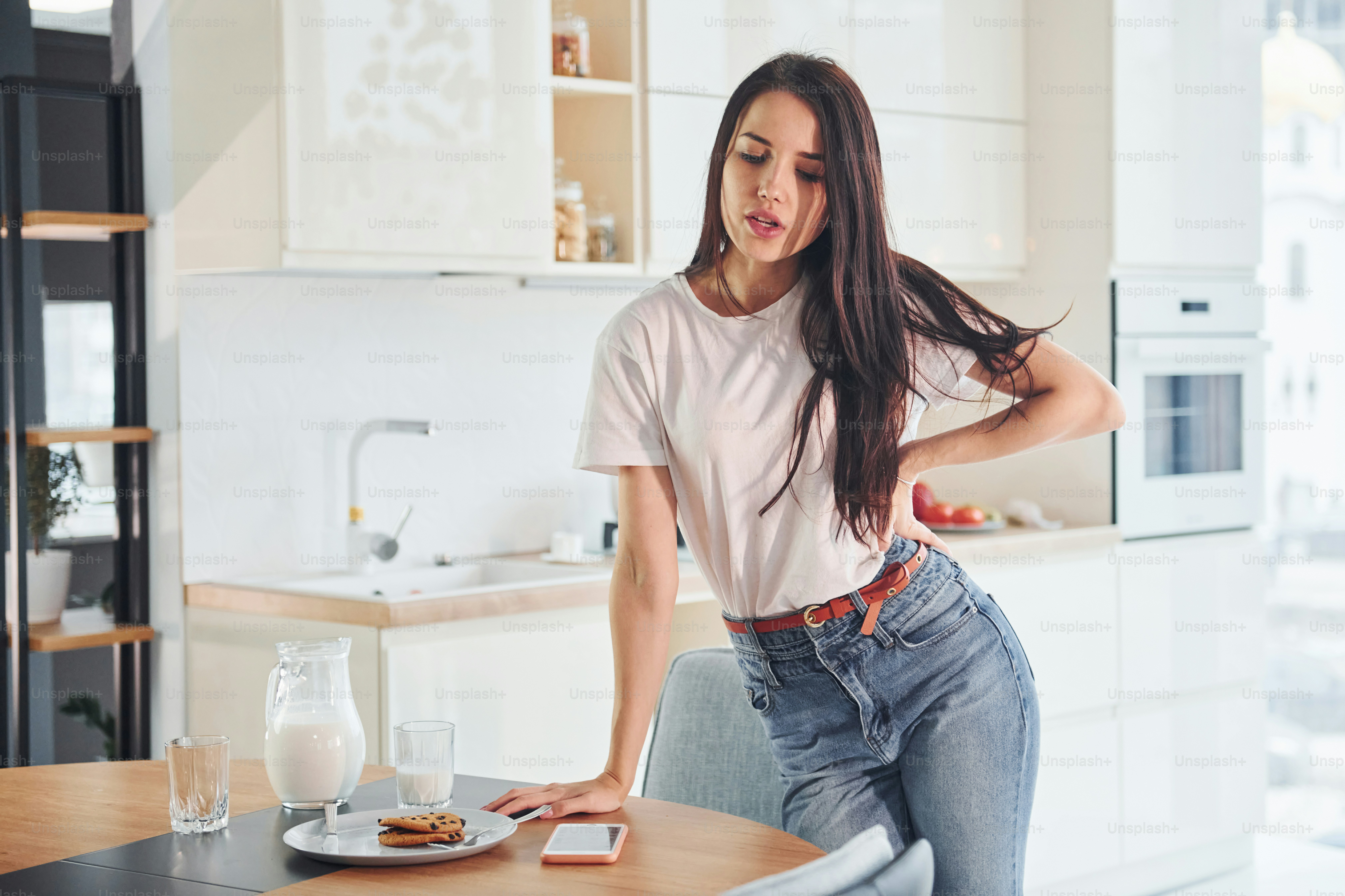 Foto Joven hermosa morena con ropa informal en el interior de la cocina ...