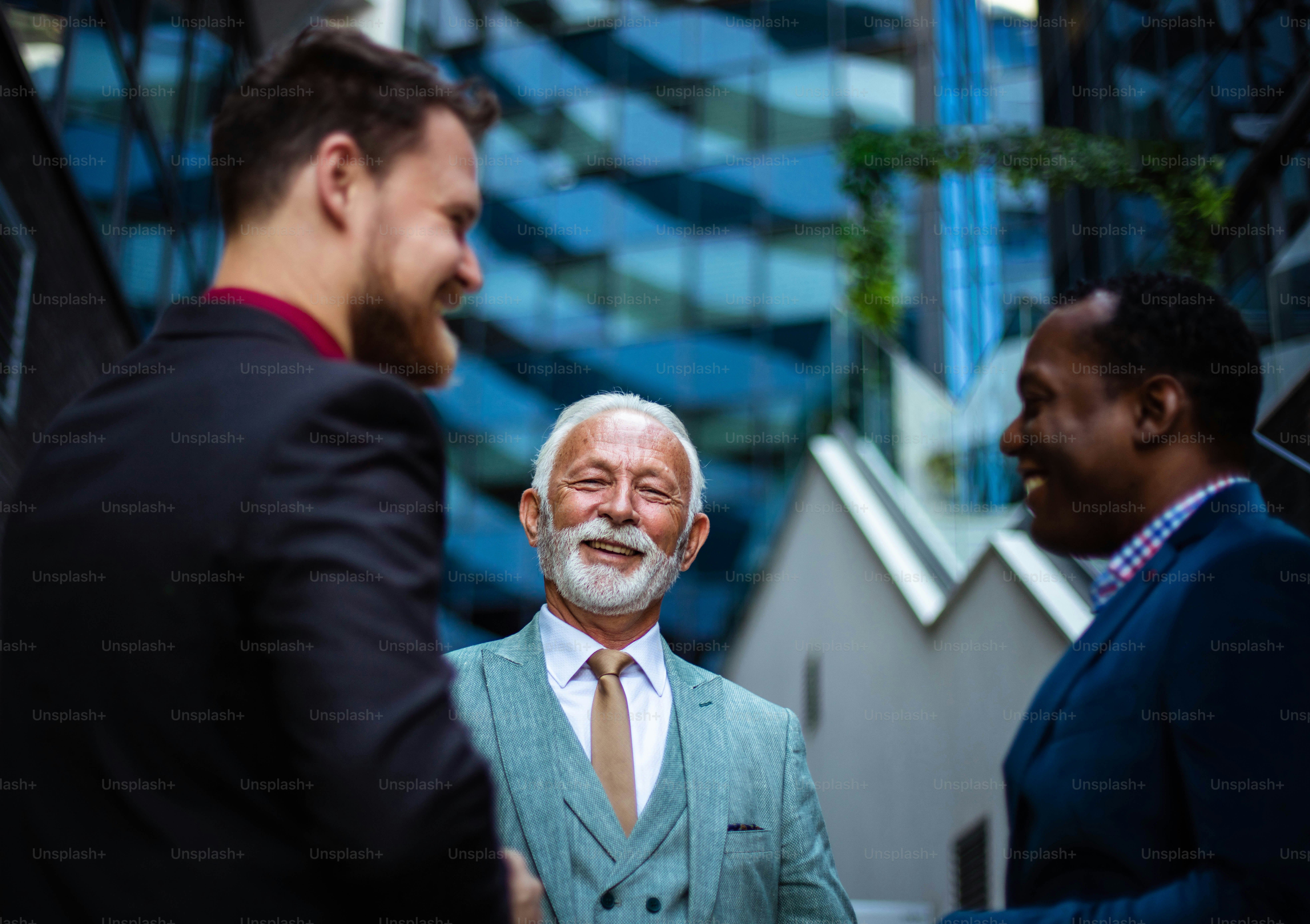 Three business men talking outside. Focus is on senior man. photo ...