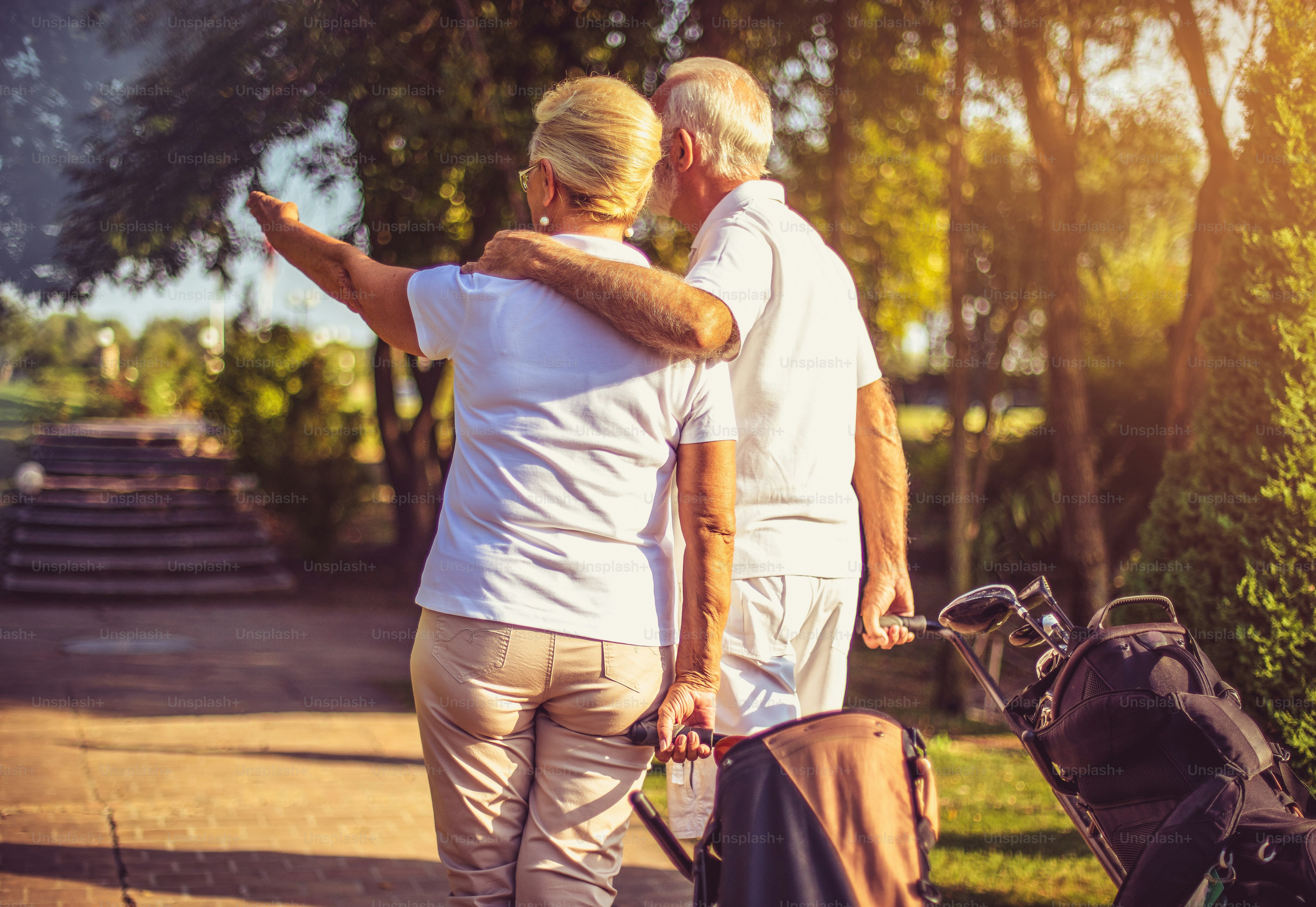 Senior golfers on golf course in hug. photo – Senior couple Image on ...
