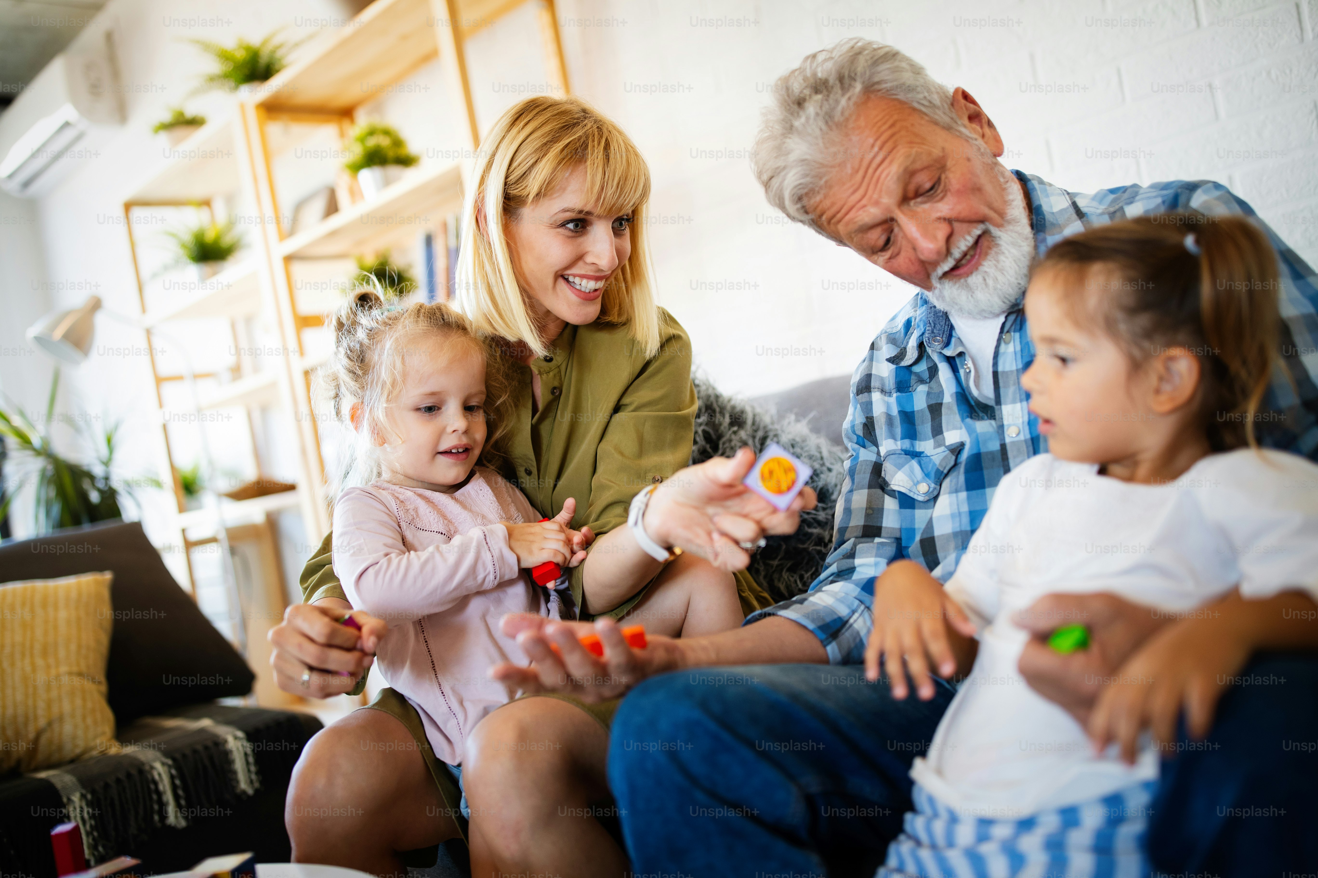 Mature grandparents playing with grandchildren and having fun with ...