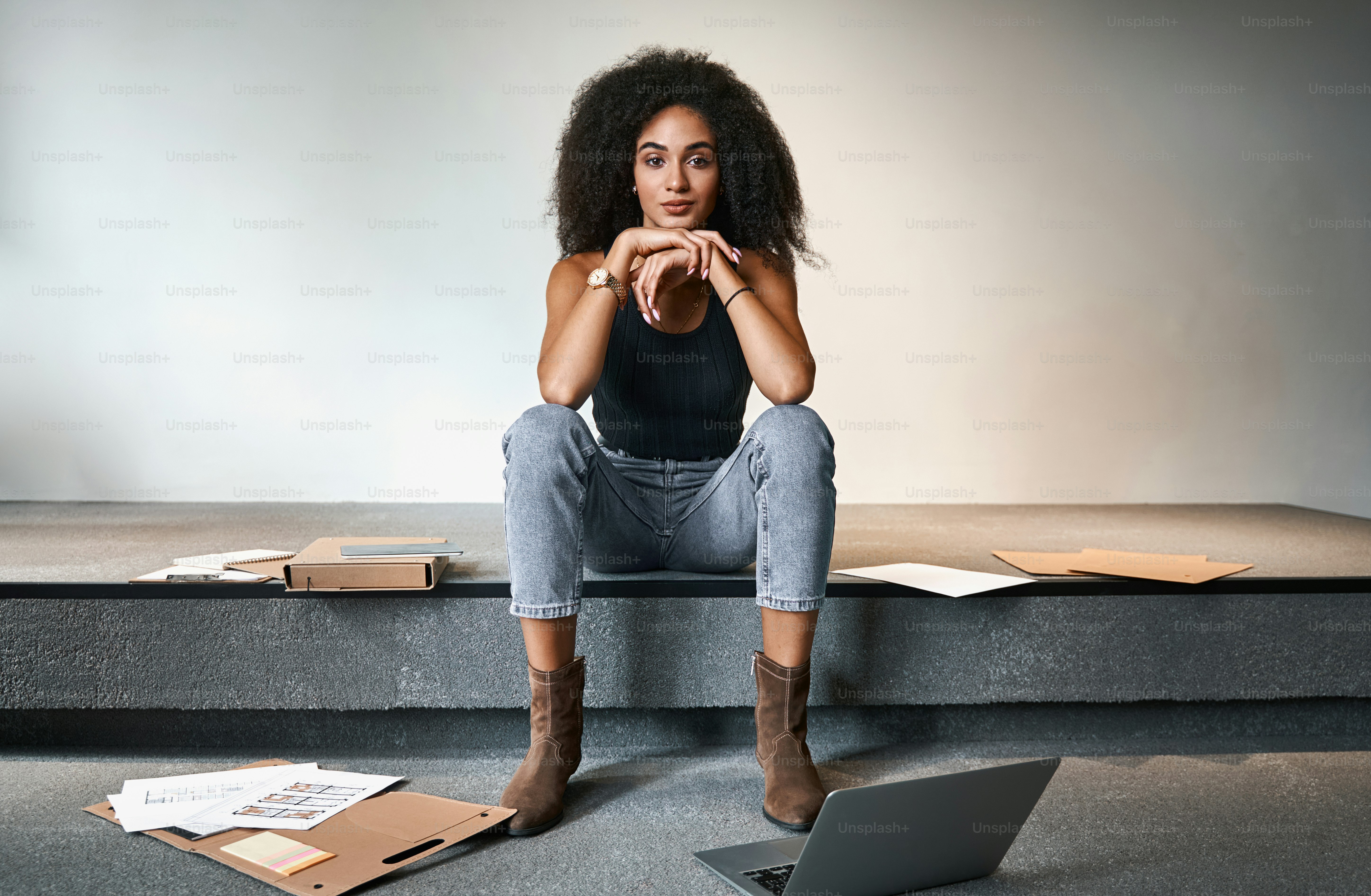 Attractive young woman sitting alone surrounded by piles of document ...