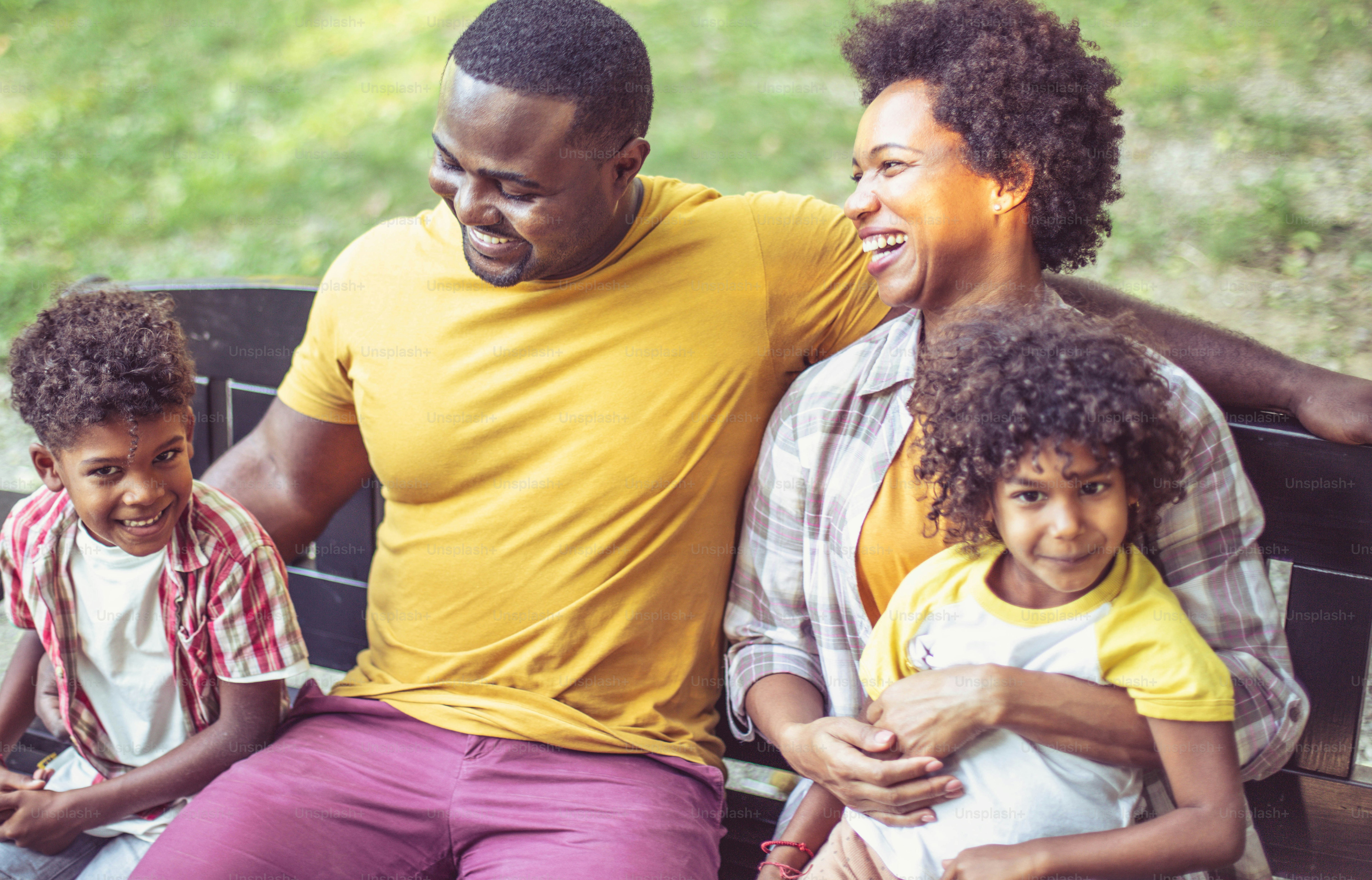 Family day. African American family walking trough park. photo – Black ...
