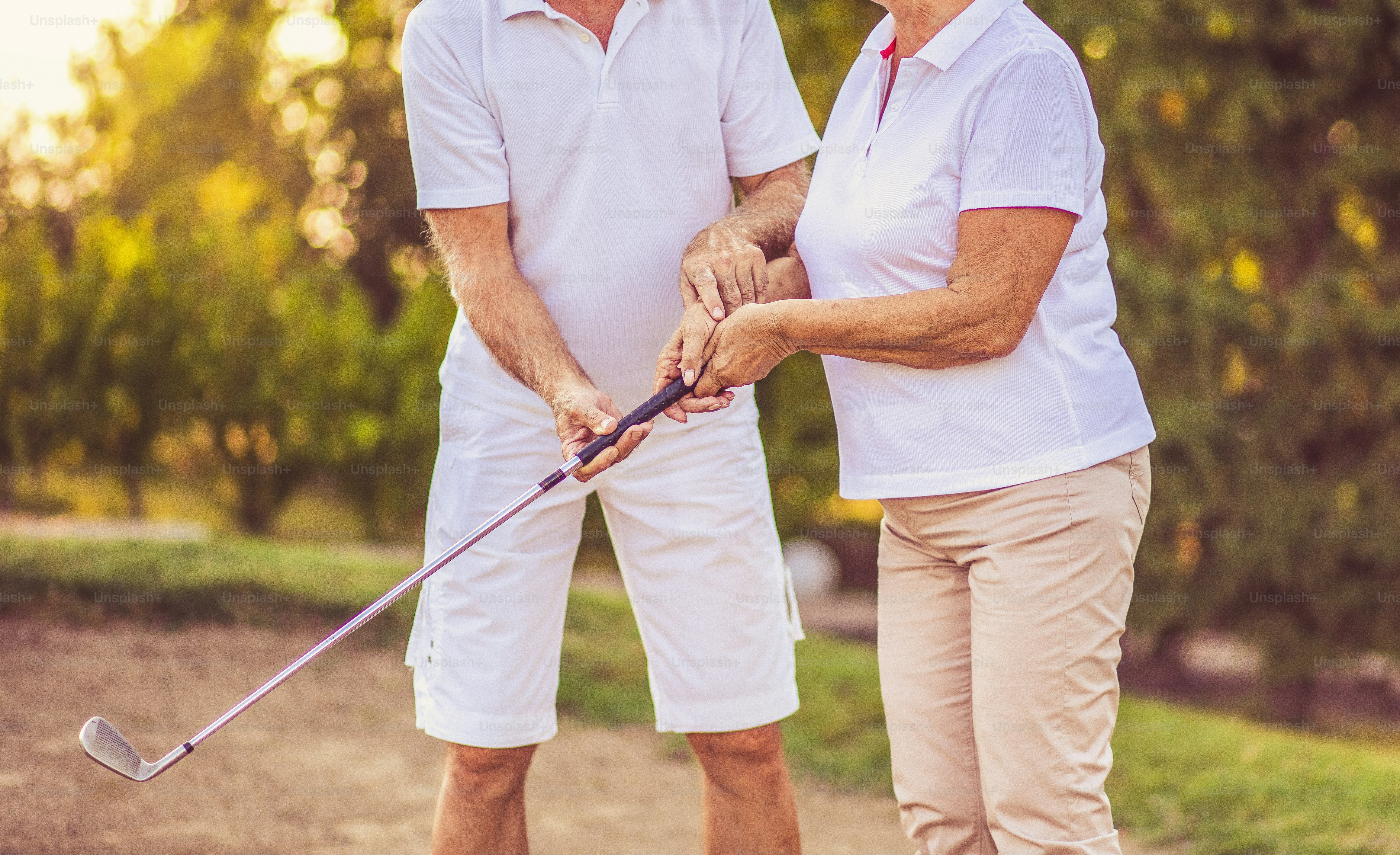 Senior couple playing golf together. Man helping woman in play. photo ...