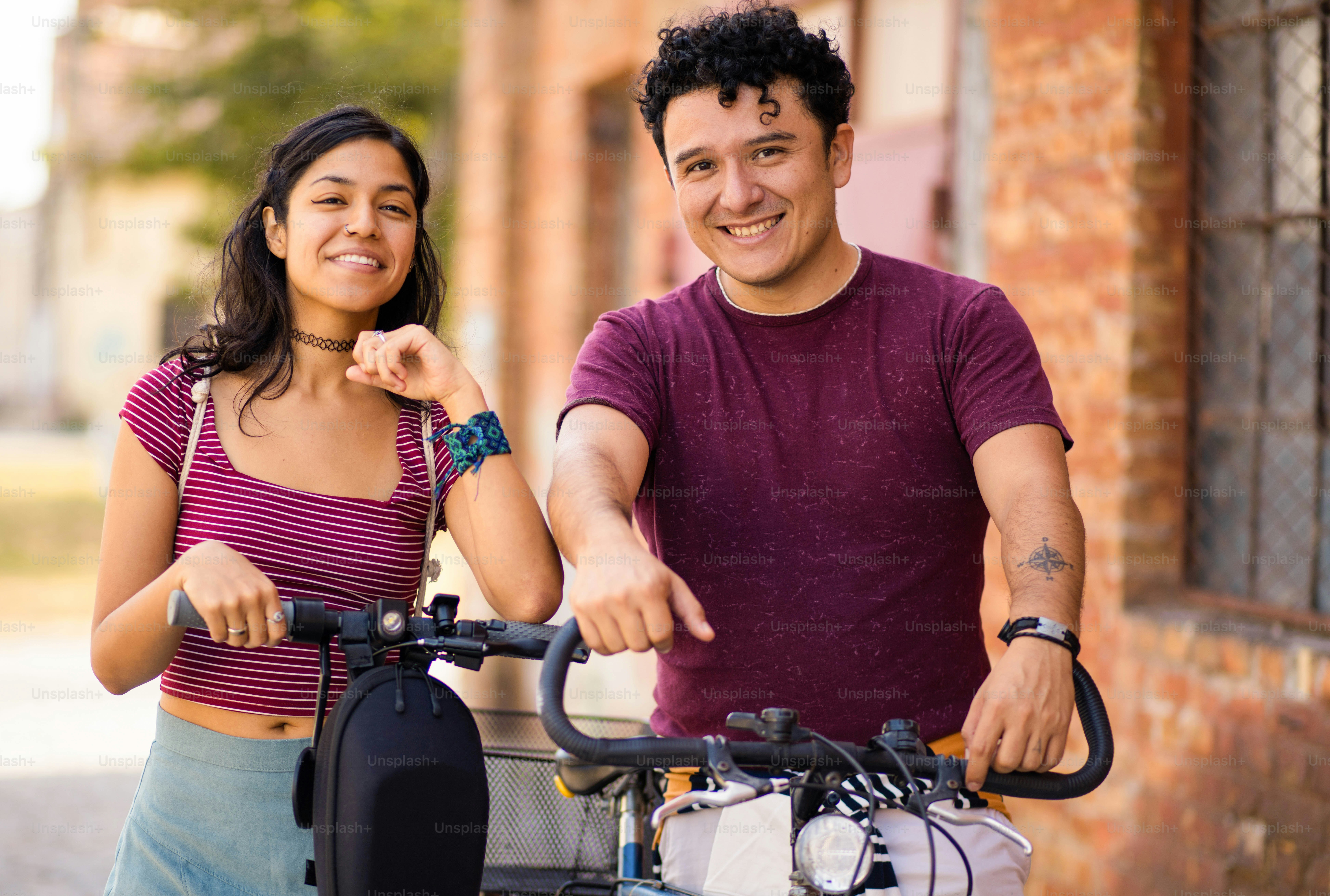 Jeune couple dans la rue avec vélo et trottinette électrique. photo ...