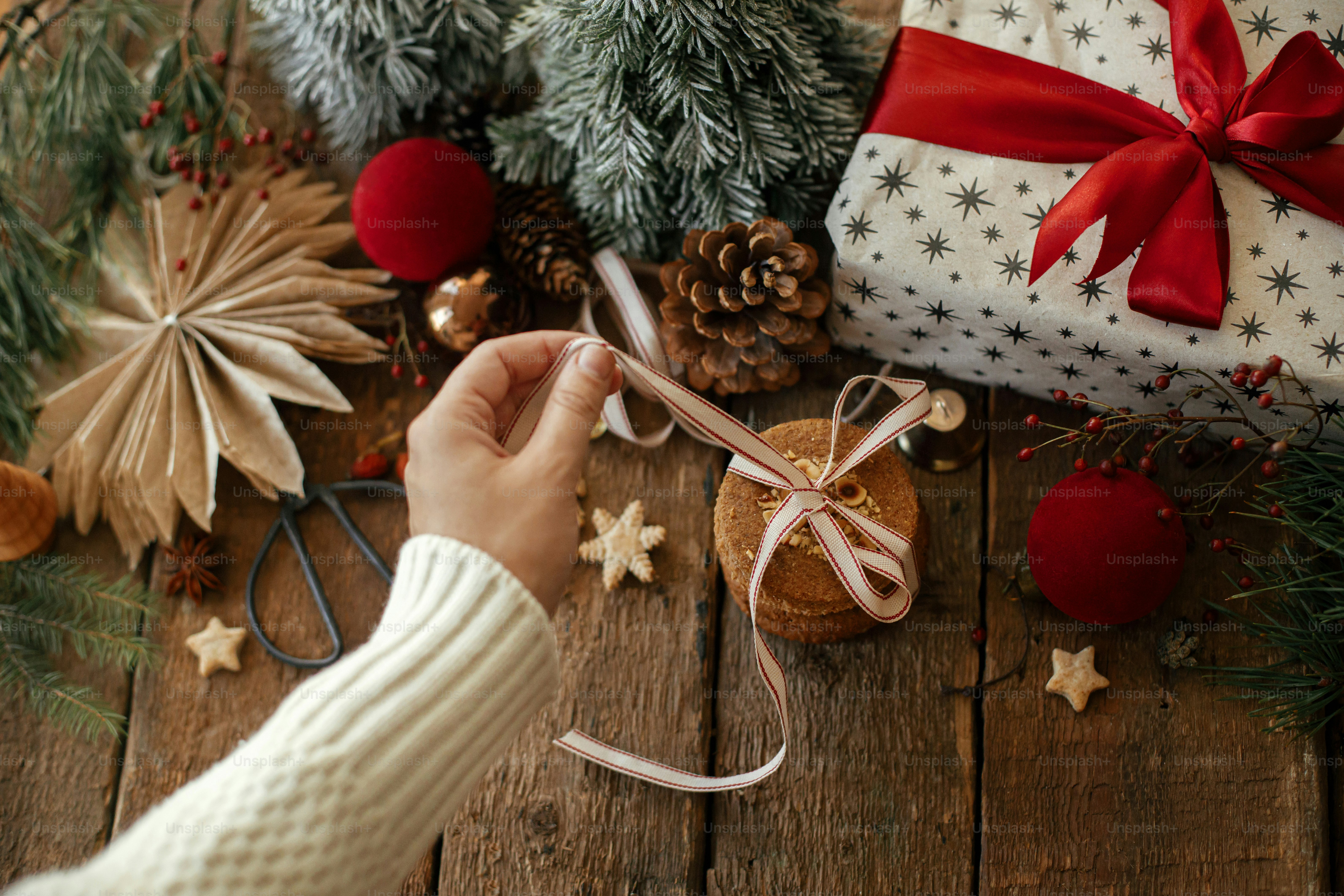 ¡Feliz Navidad! Manos atando cinta en galletas de avena navideñas sobre ...