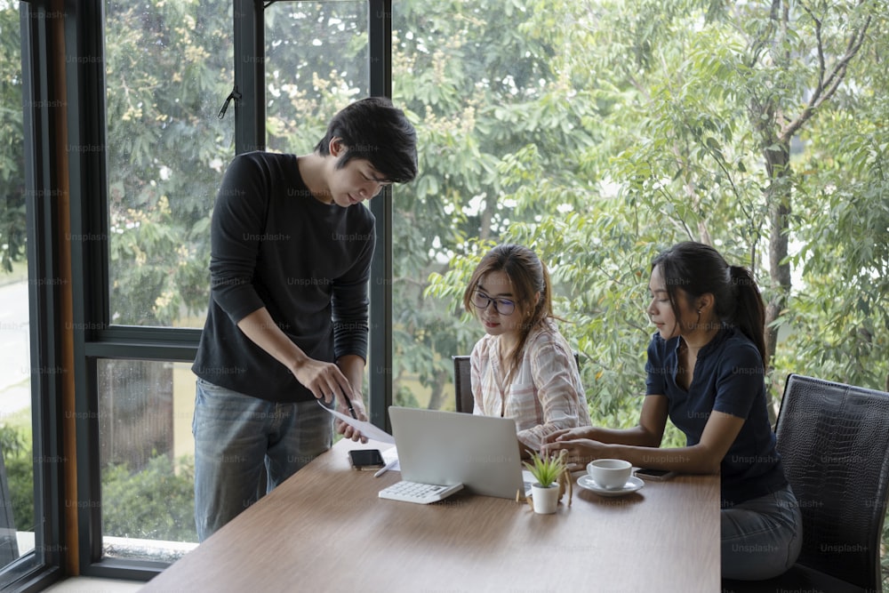 Groupe de jeunes gens d'affaires travaillant ensemble sur un nouveau ... Groupe de jeunes gens d'affaires travaillant ensemble sur un nouveau ...
