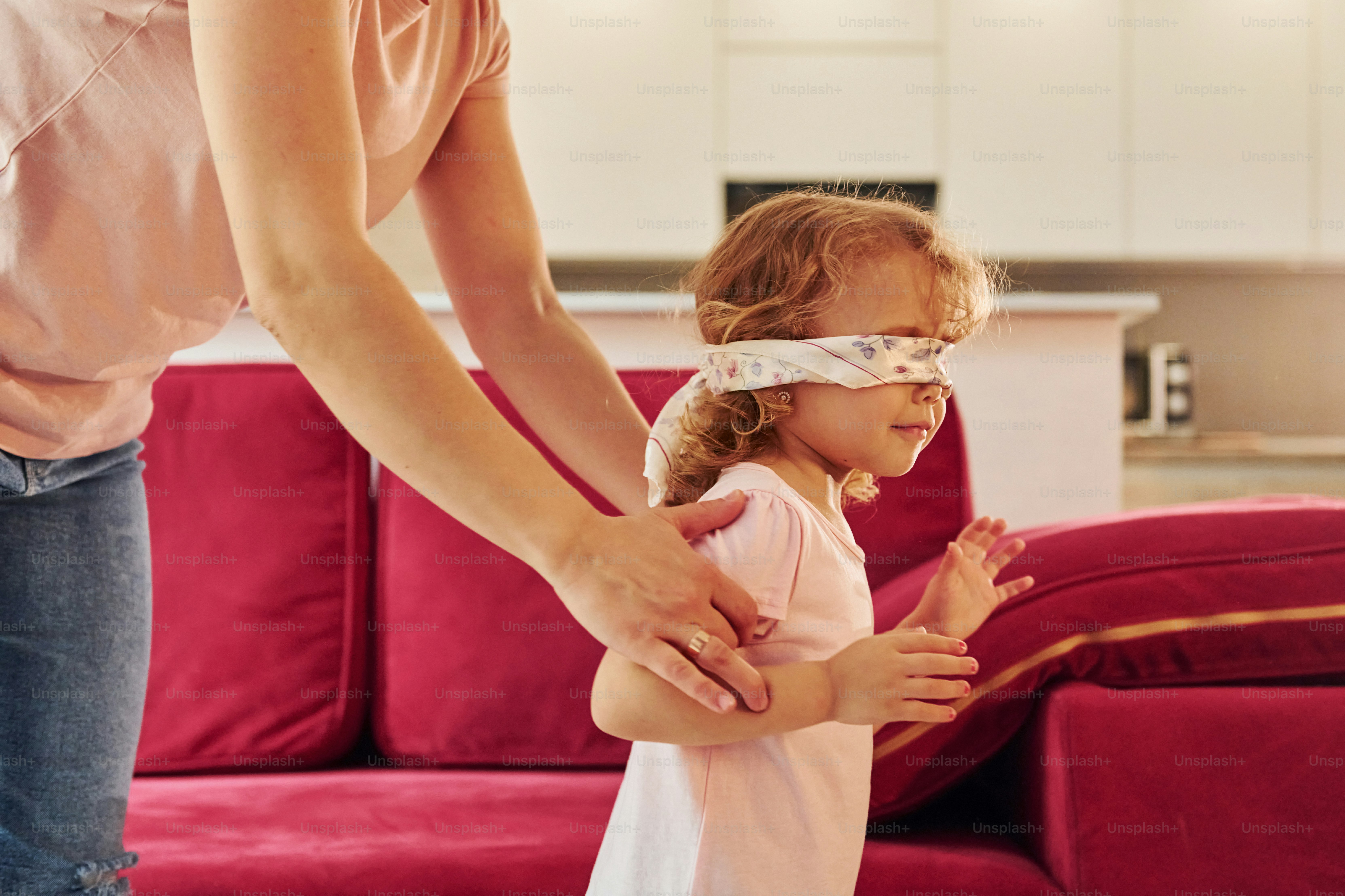 Playing game with eyes blindfolded. Young mother with her little ...
