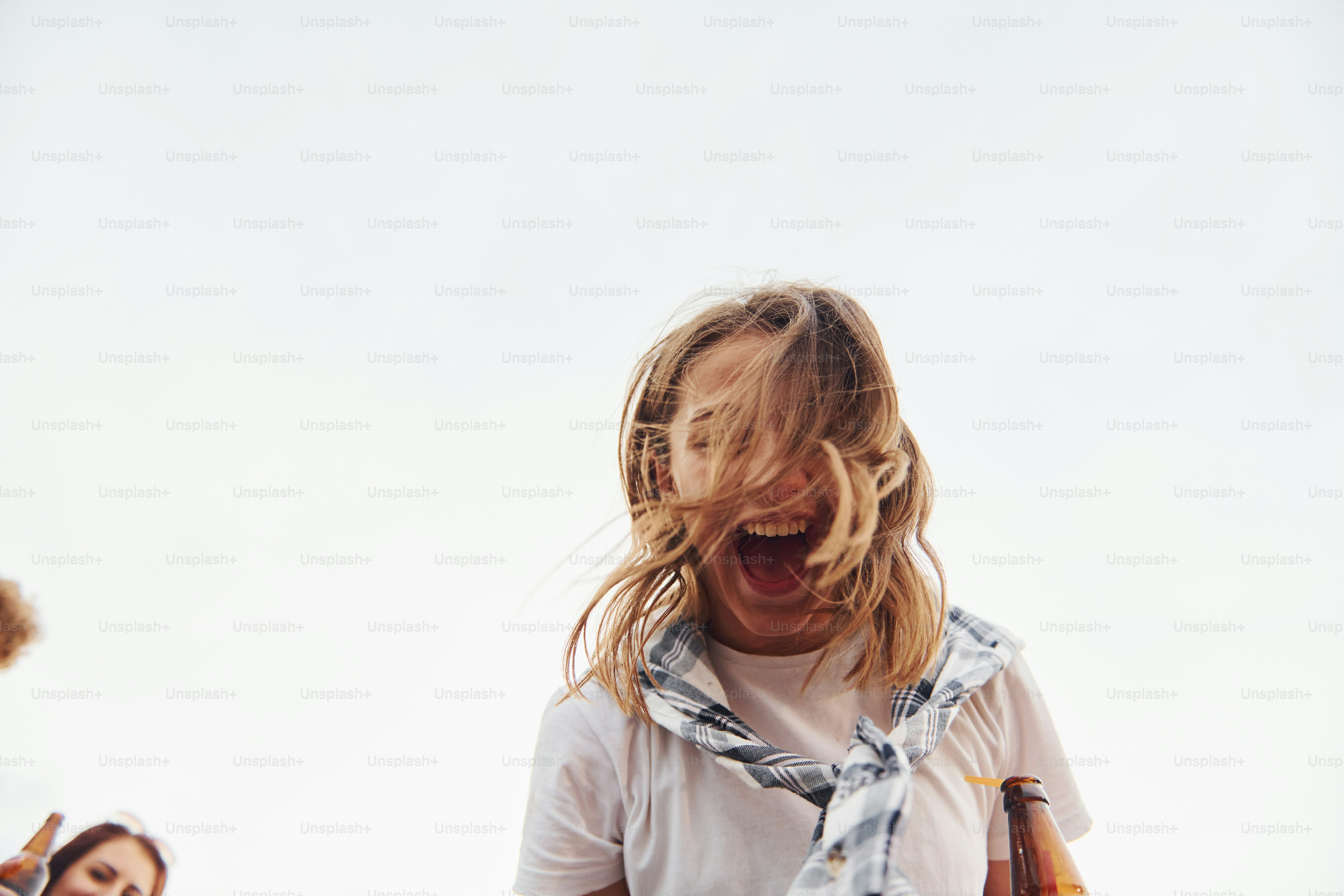 Positive smiling young girl have fun and her friends and looks into the ...