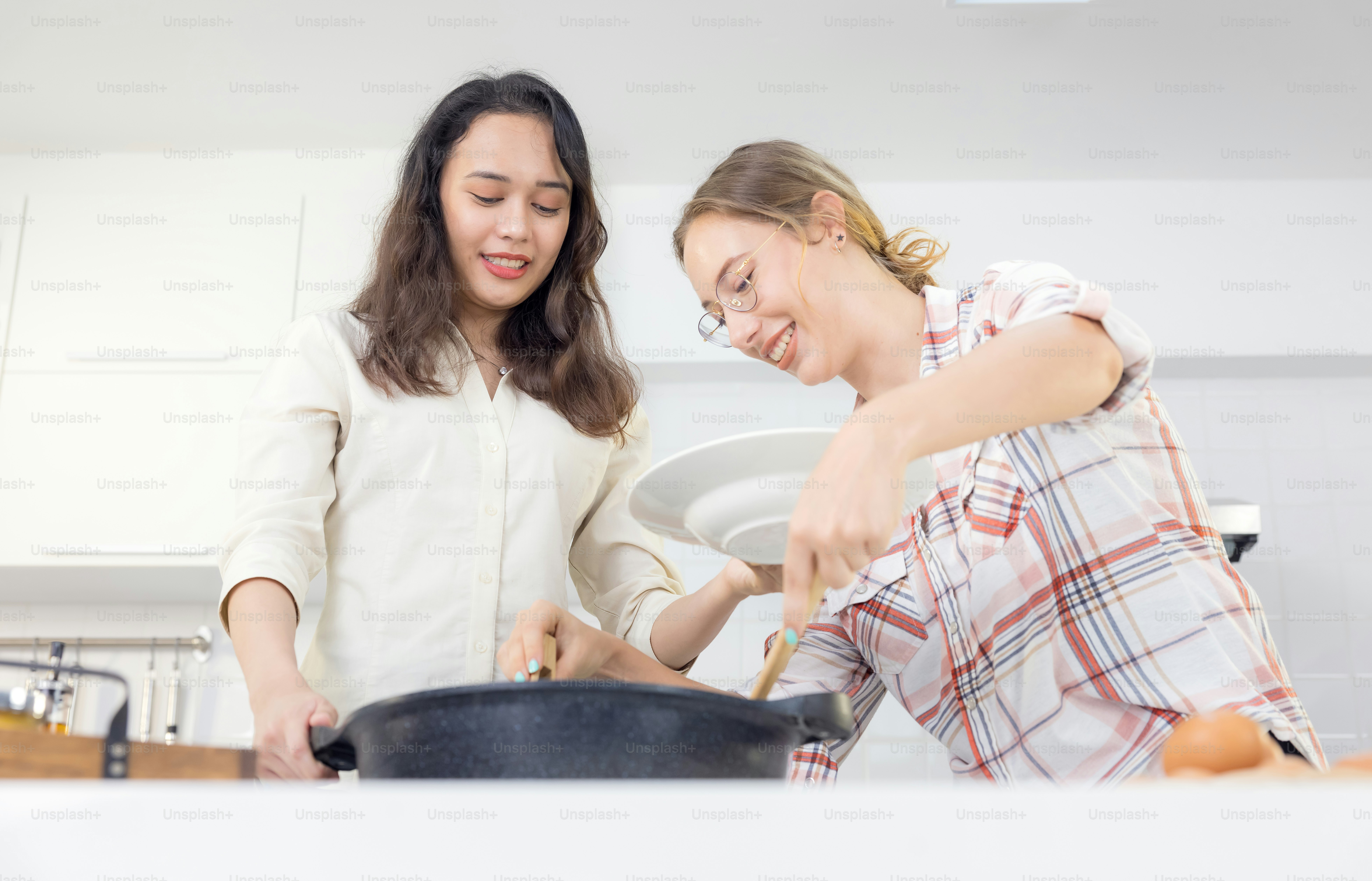 At home, two pals are having a good time in the kitchen. Sisters ...