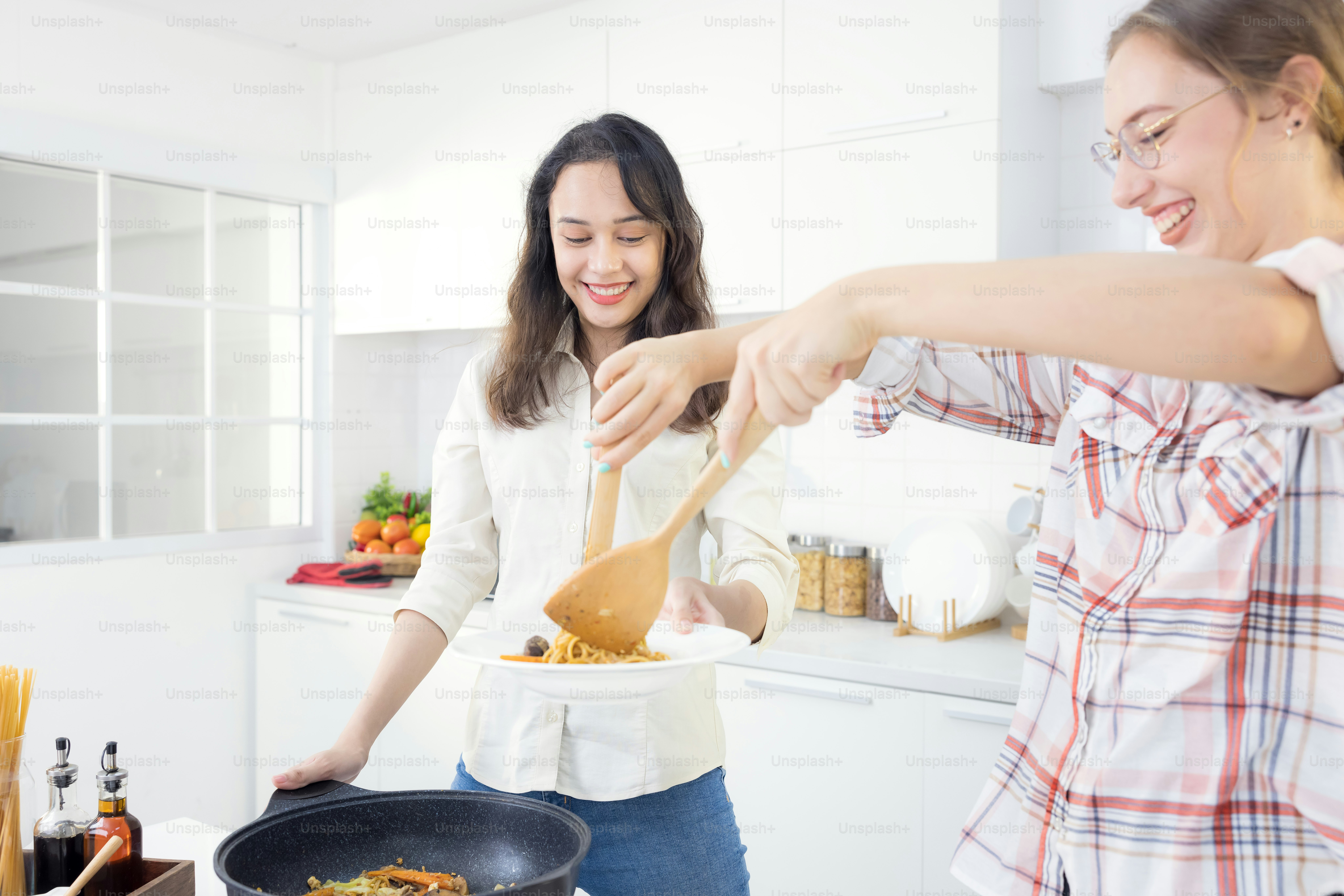 At home, two pals are having a good time in the kitchen. Sisters ...