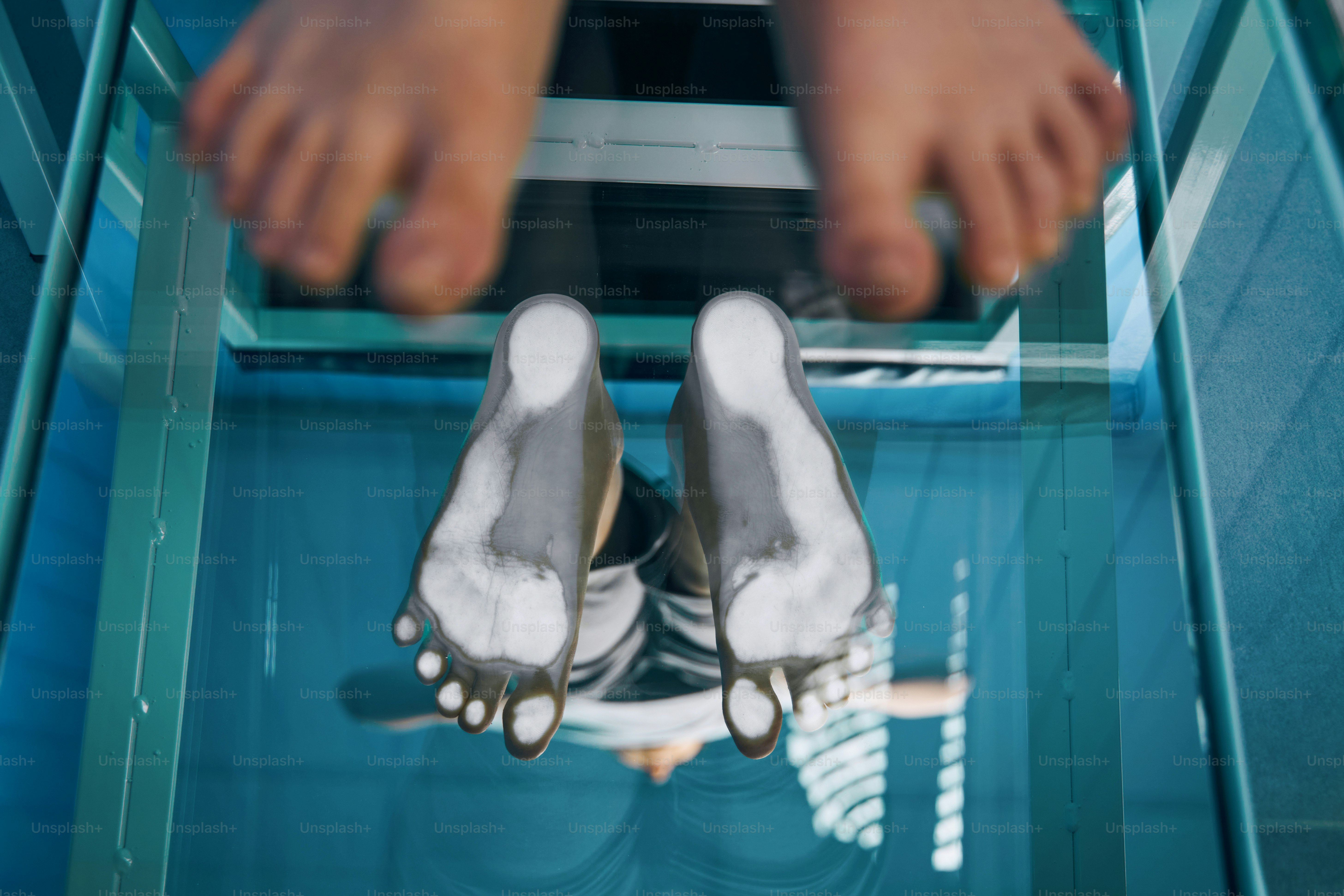 Detailed examination of bare feet of girl on plantoscope platform at ...