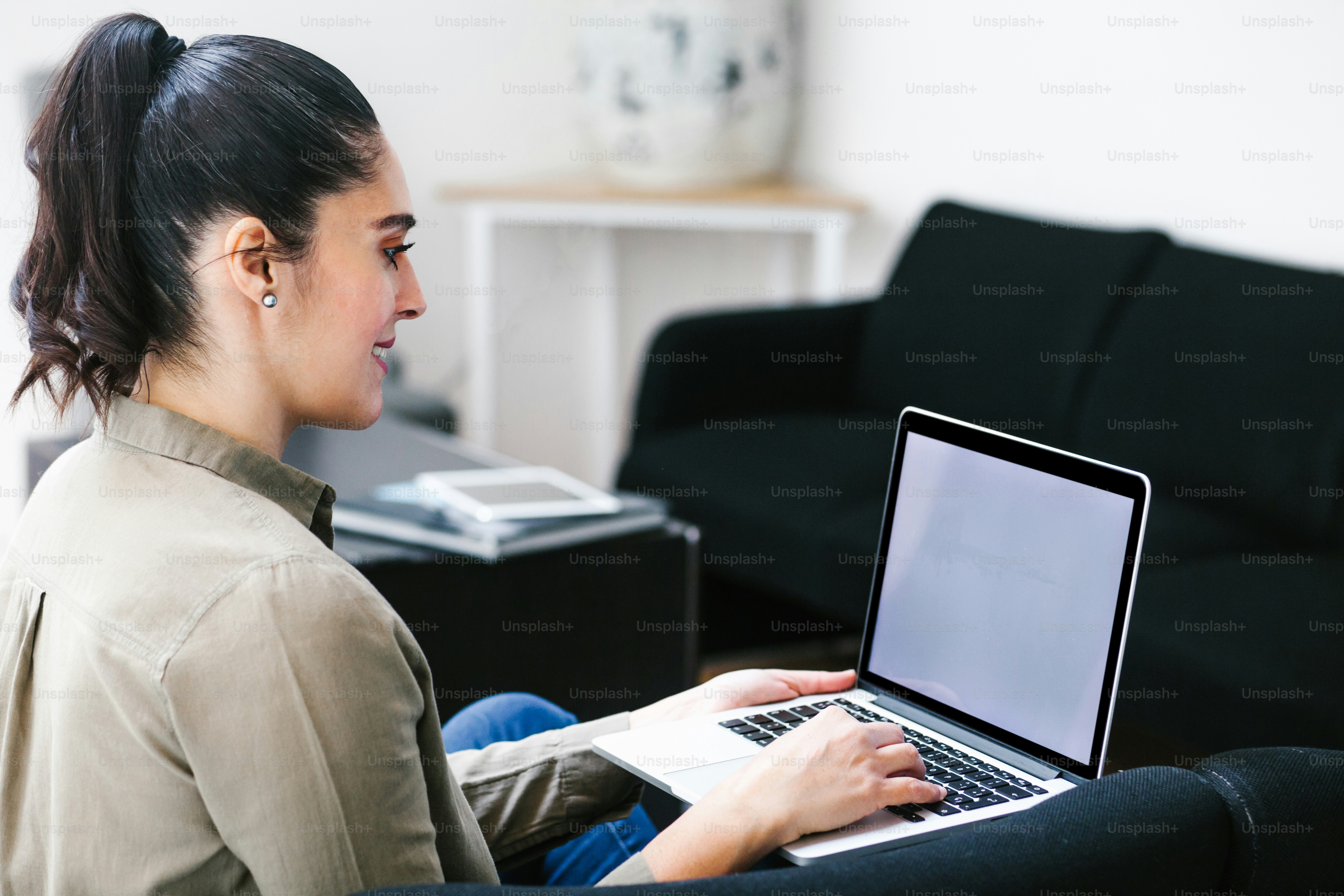 Latin woman with computer on sofa at home in Mexico city photo ...