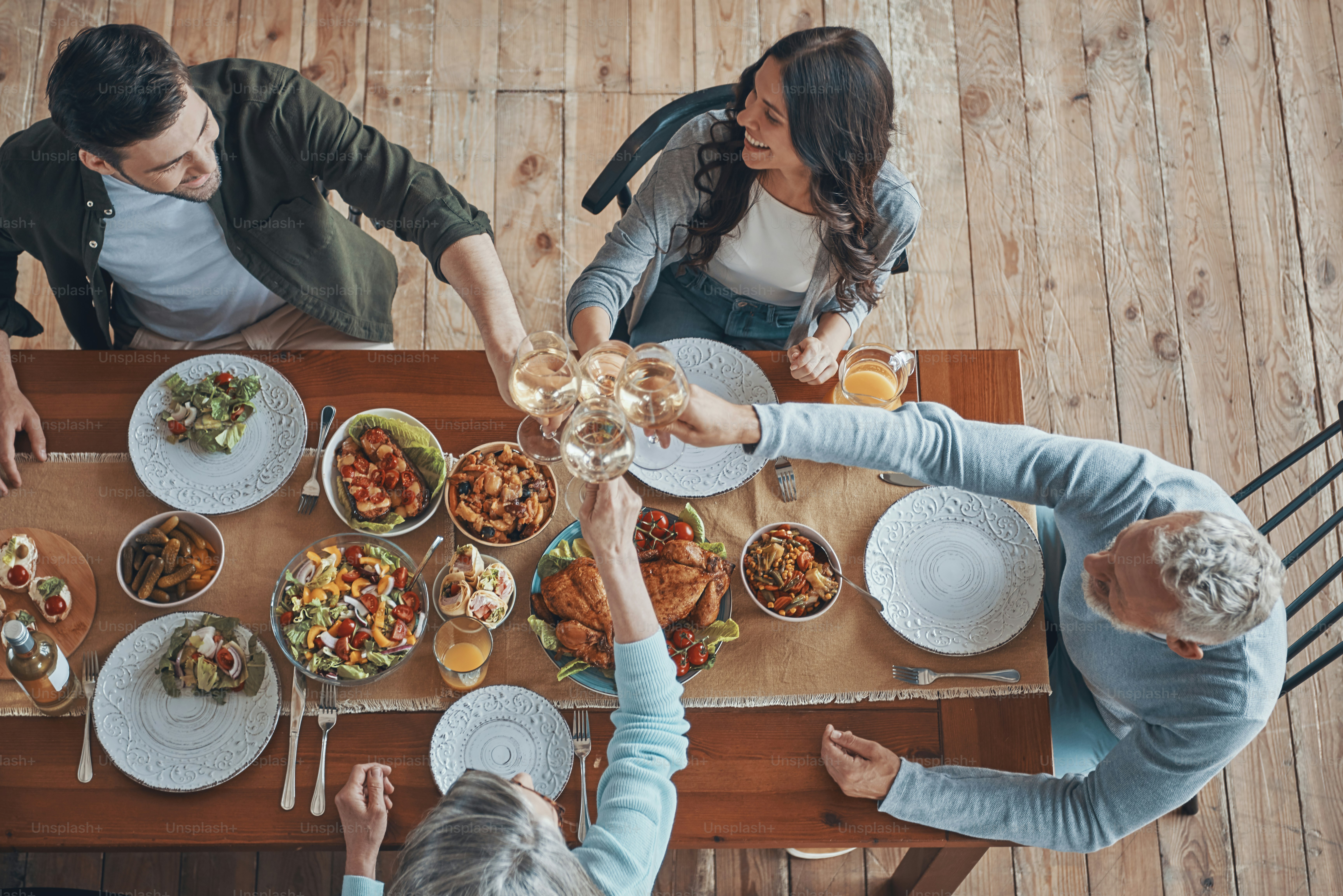 Top view of multi-generation family toasting while having dinner ...