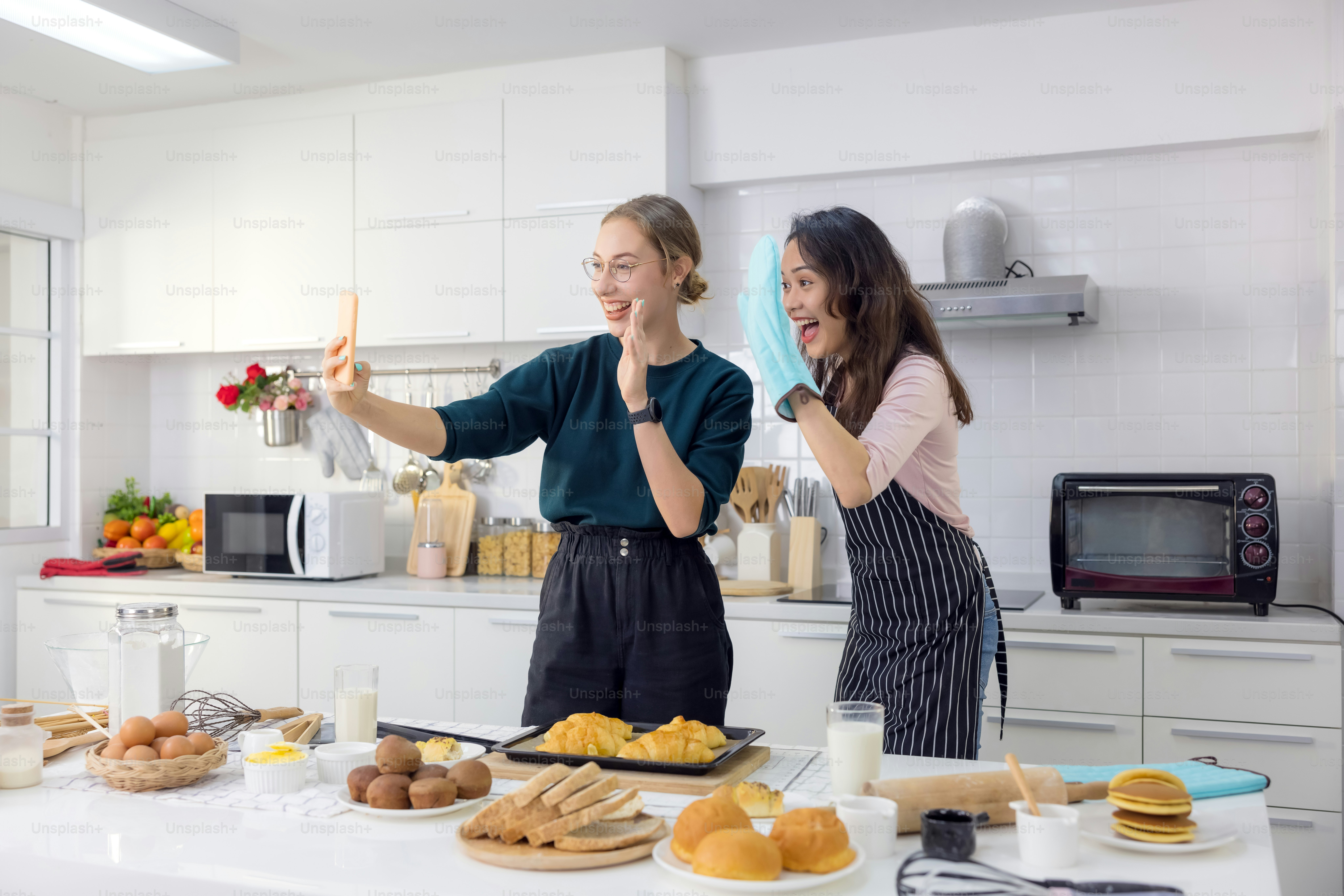 Two female pals are having fun while taking a selfie breakfast in the ...